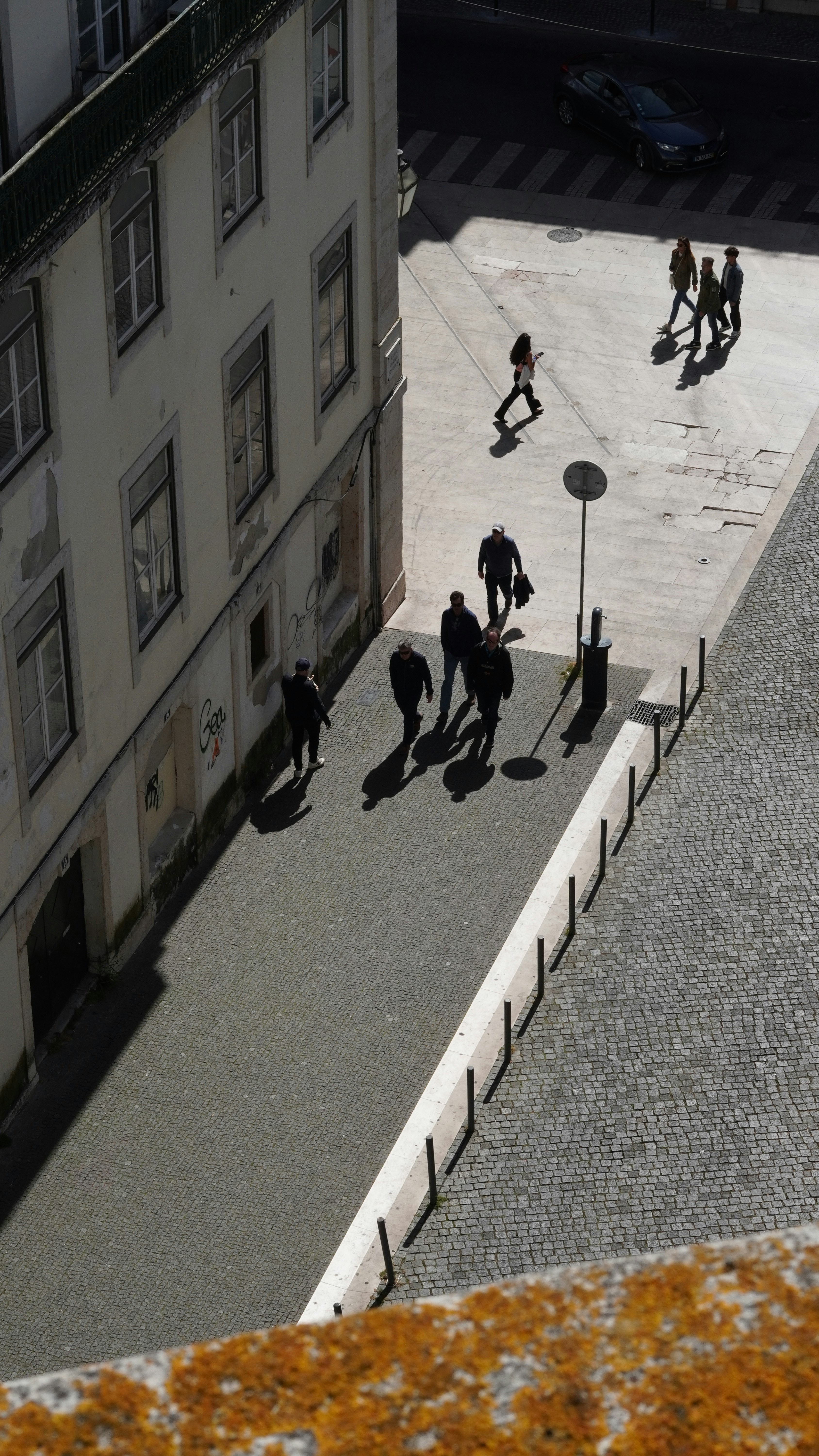 Above the Grid: Pedestrian Shadows Weave Through a Sunlit City Block