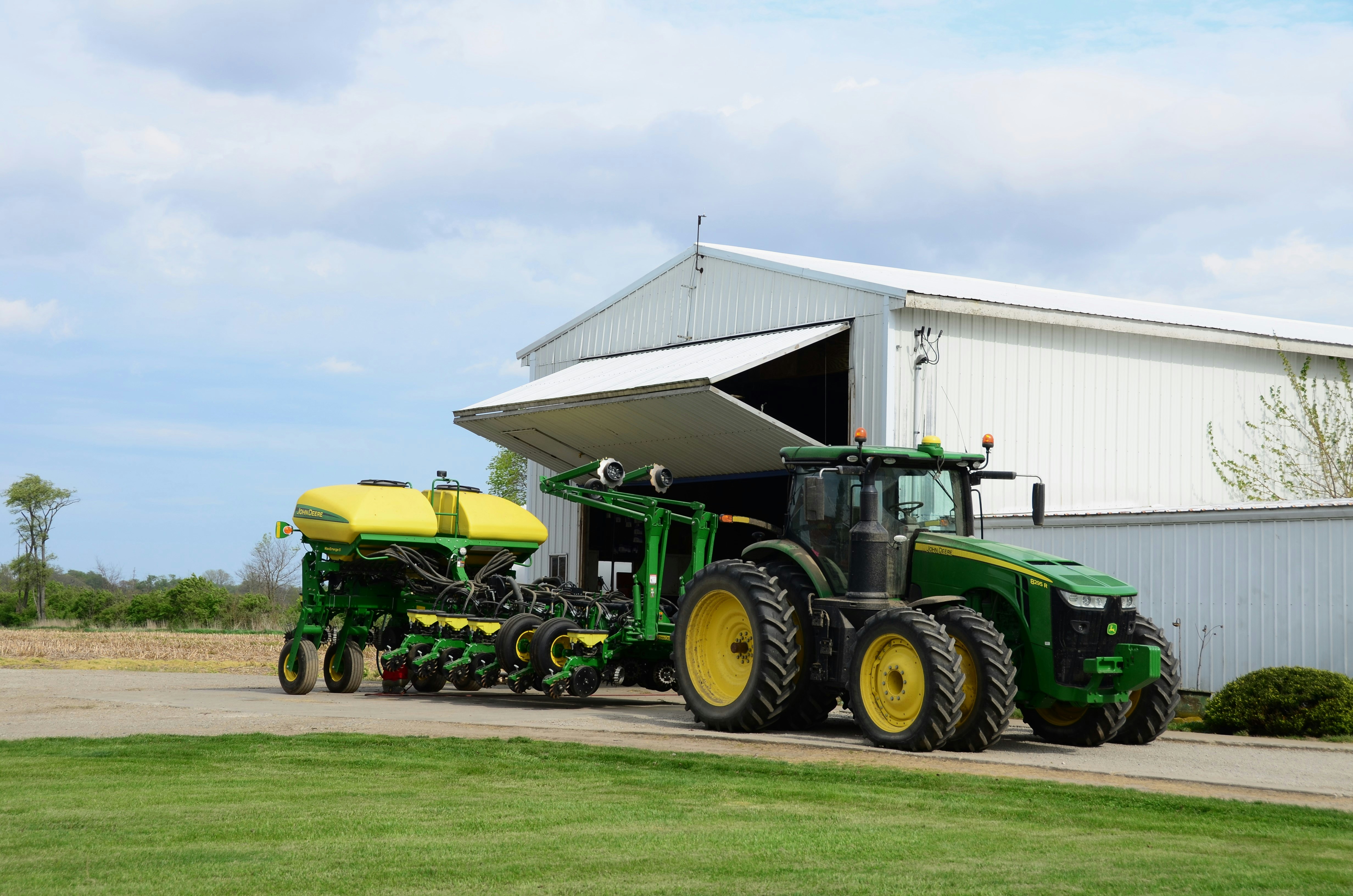 A tractor and a trailer parked in front of a barn photo – Free Grass ...