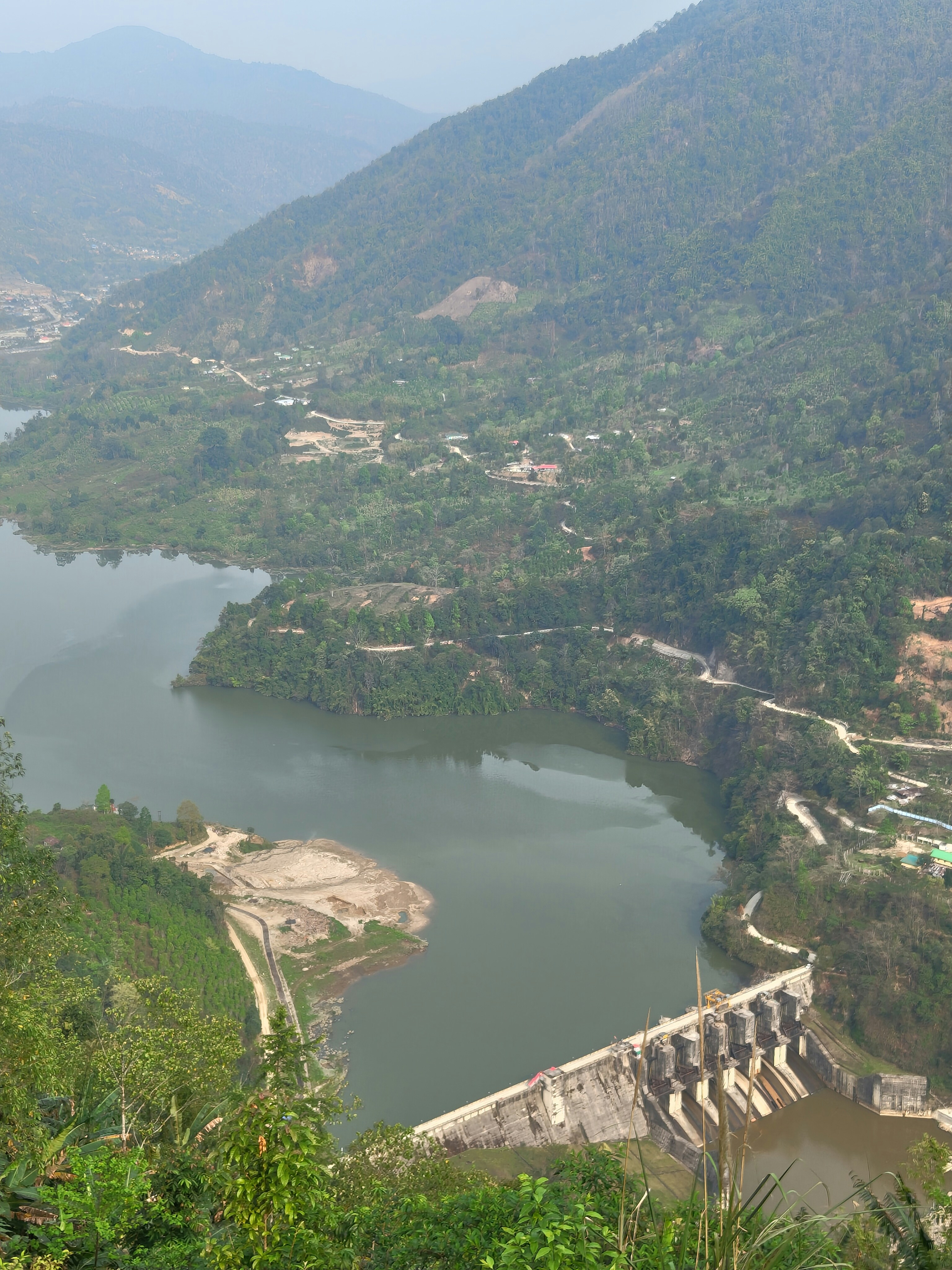 A large body of water surrounded by a lush green hillside photo – Free ...