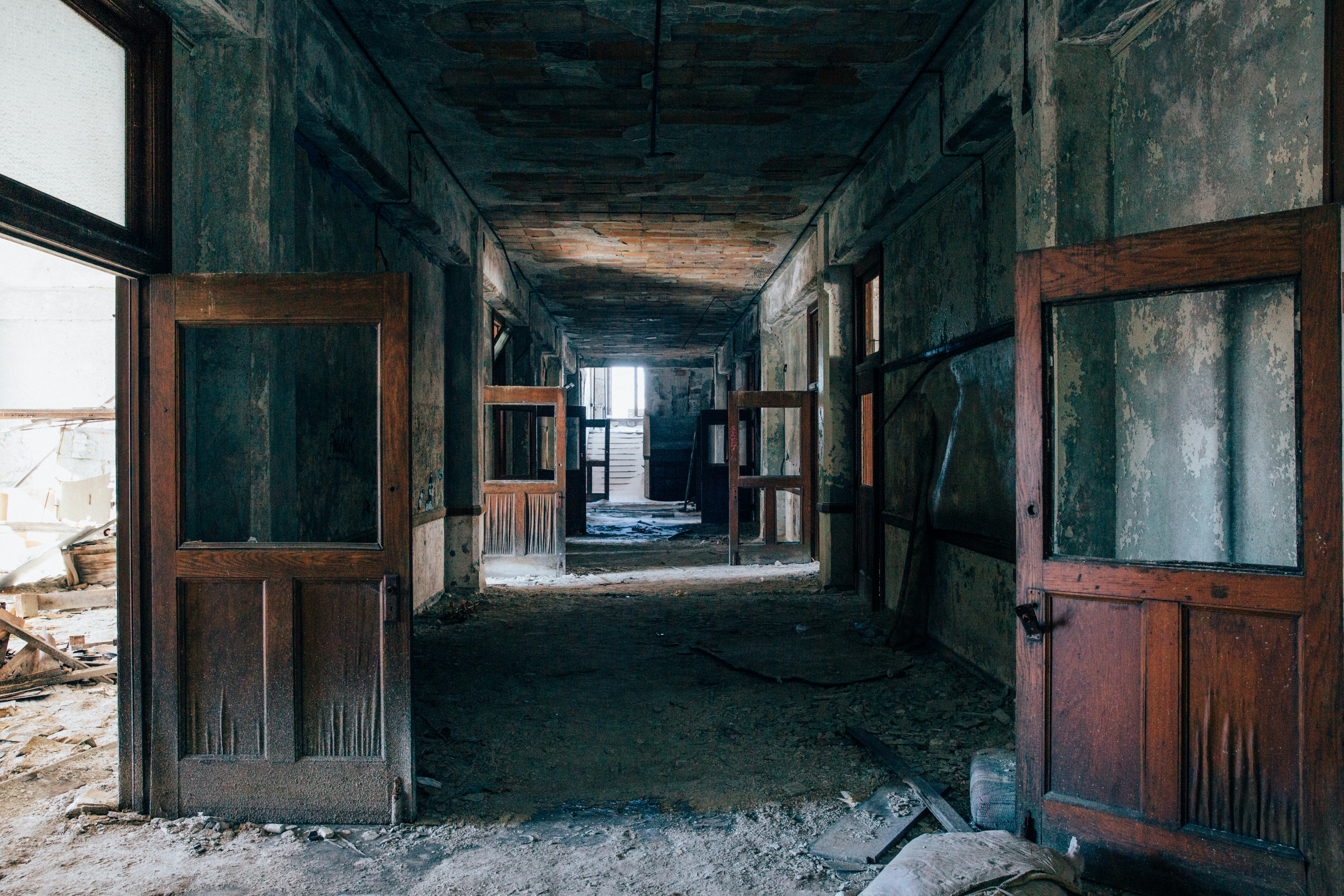 A hallway in an abandoned building with broken doors photo – Free ...