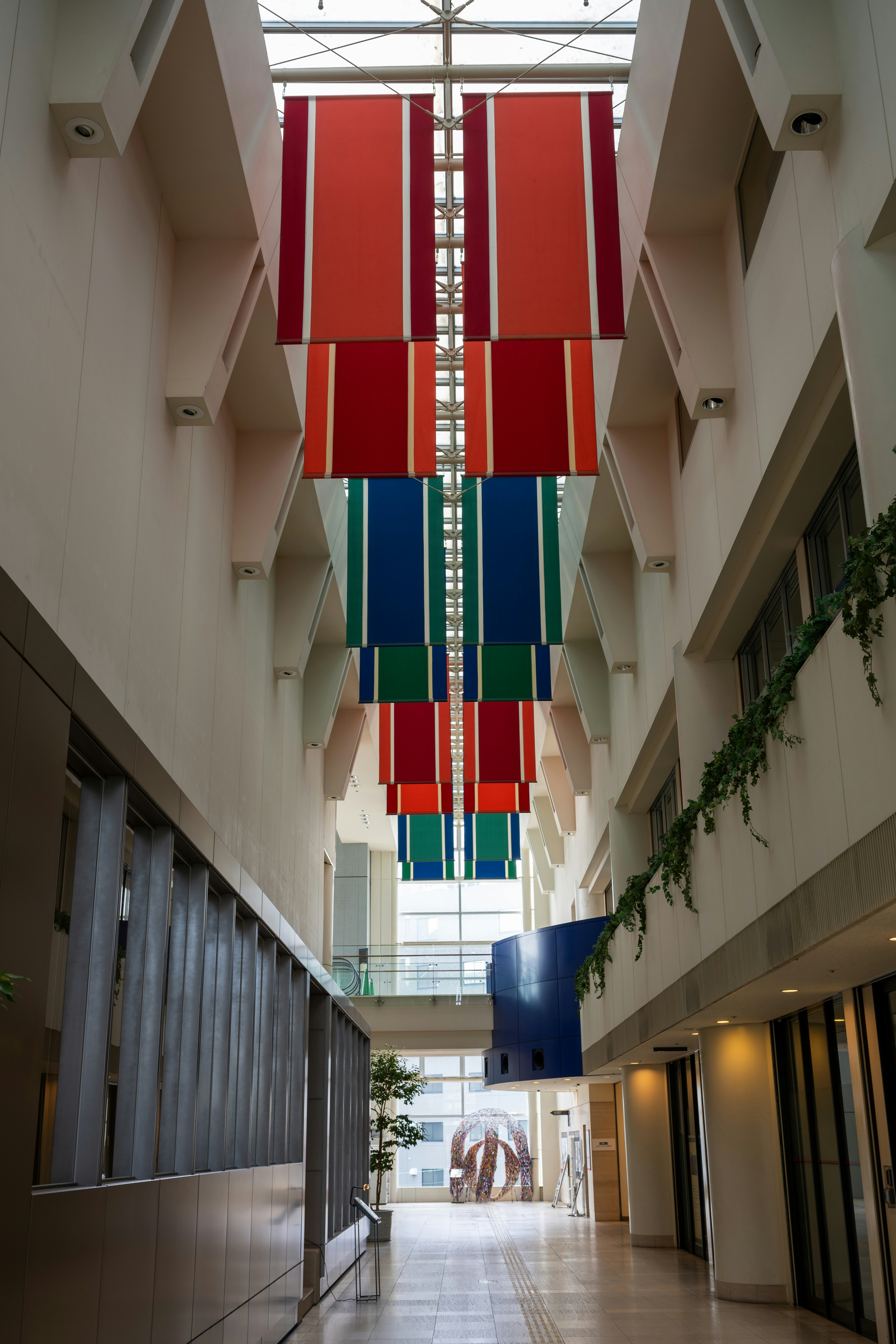 A very long hallway with a bunch of colorful flags hanging from it's ...