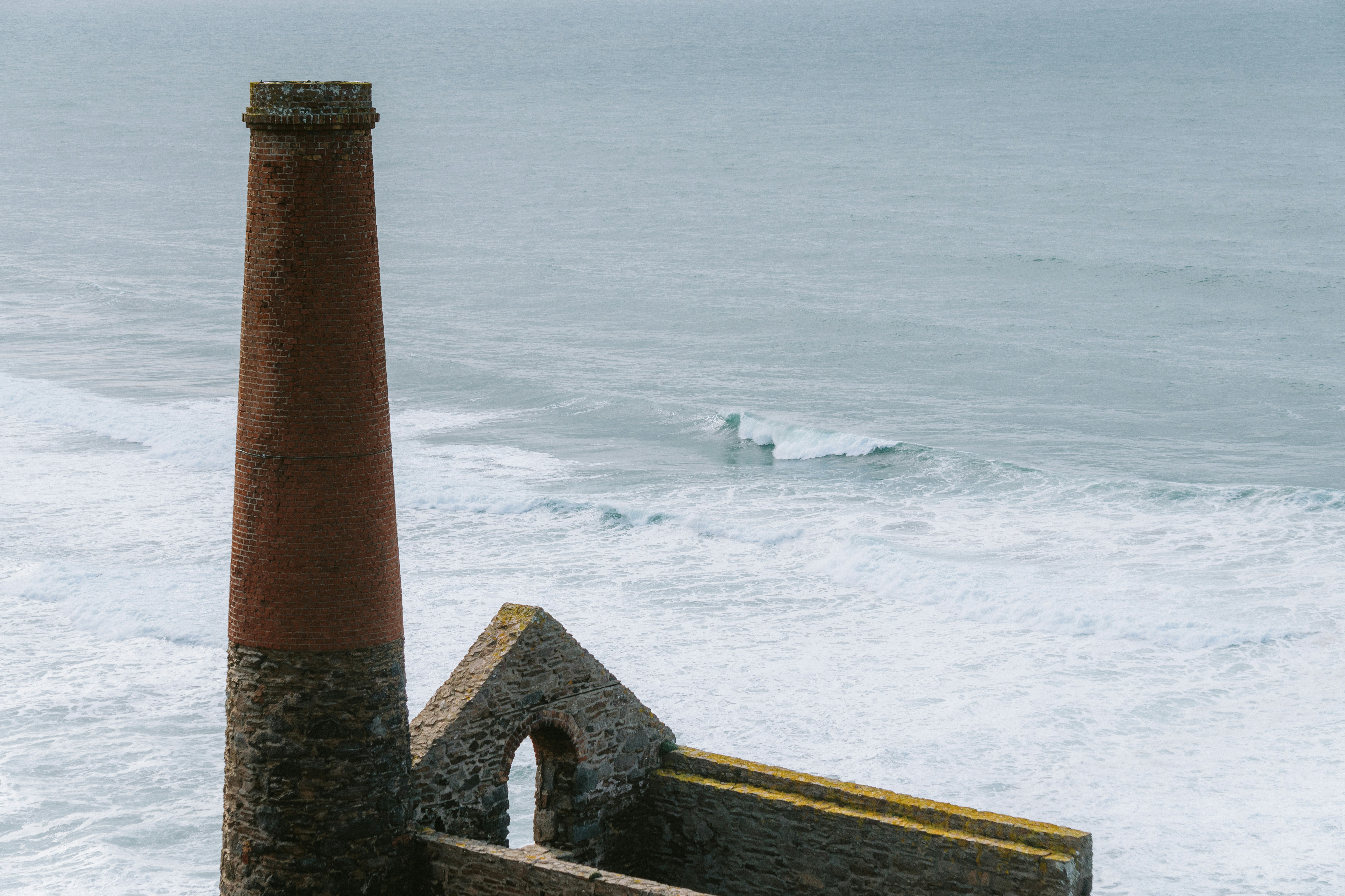 Lighthouse silhouette over a restless inlet