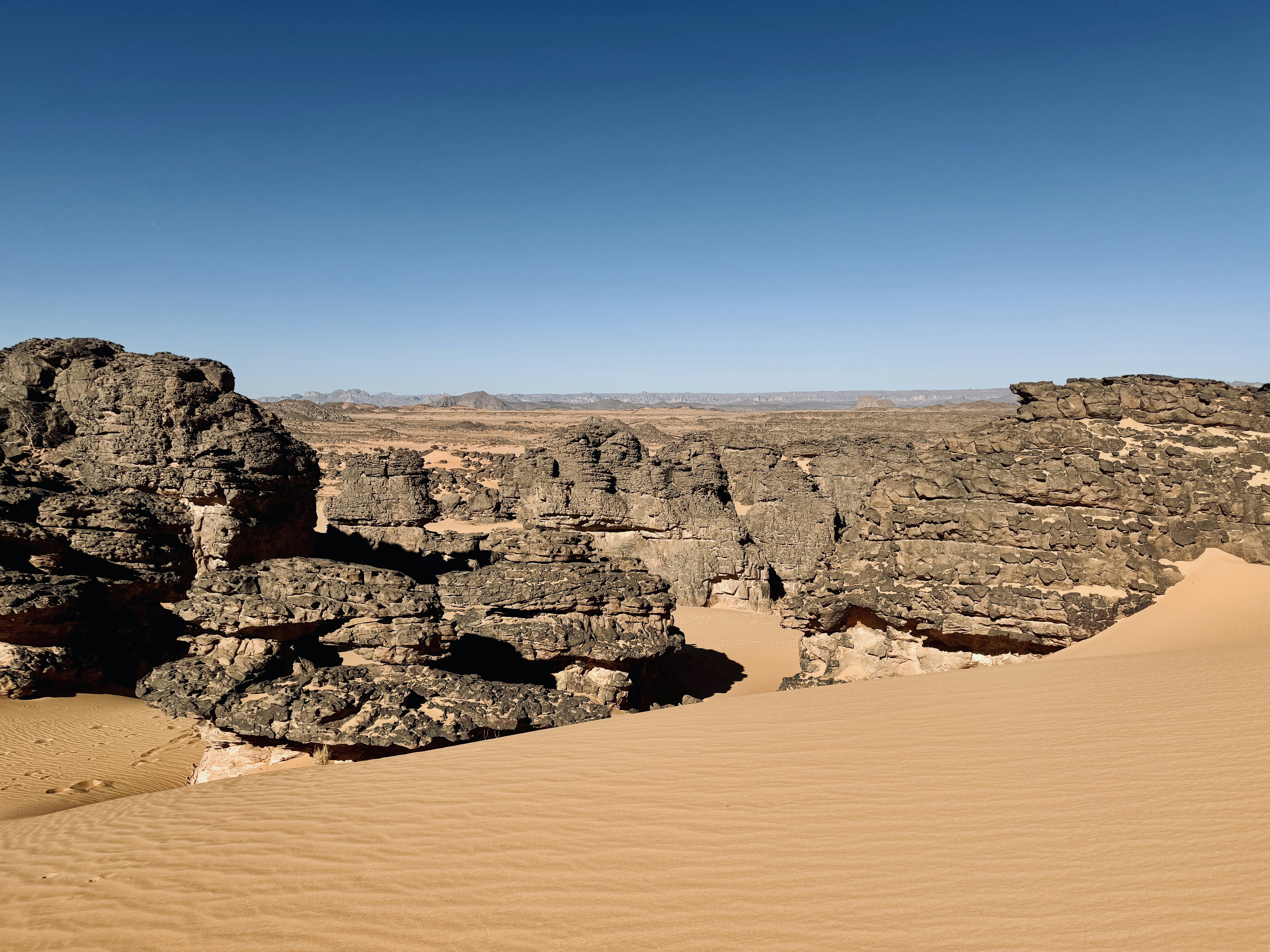 A desert landscape with rocks and sand in the foreground photo – Free ...