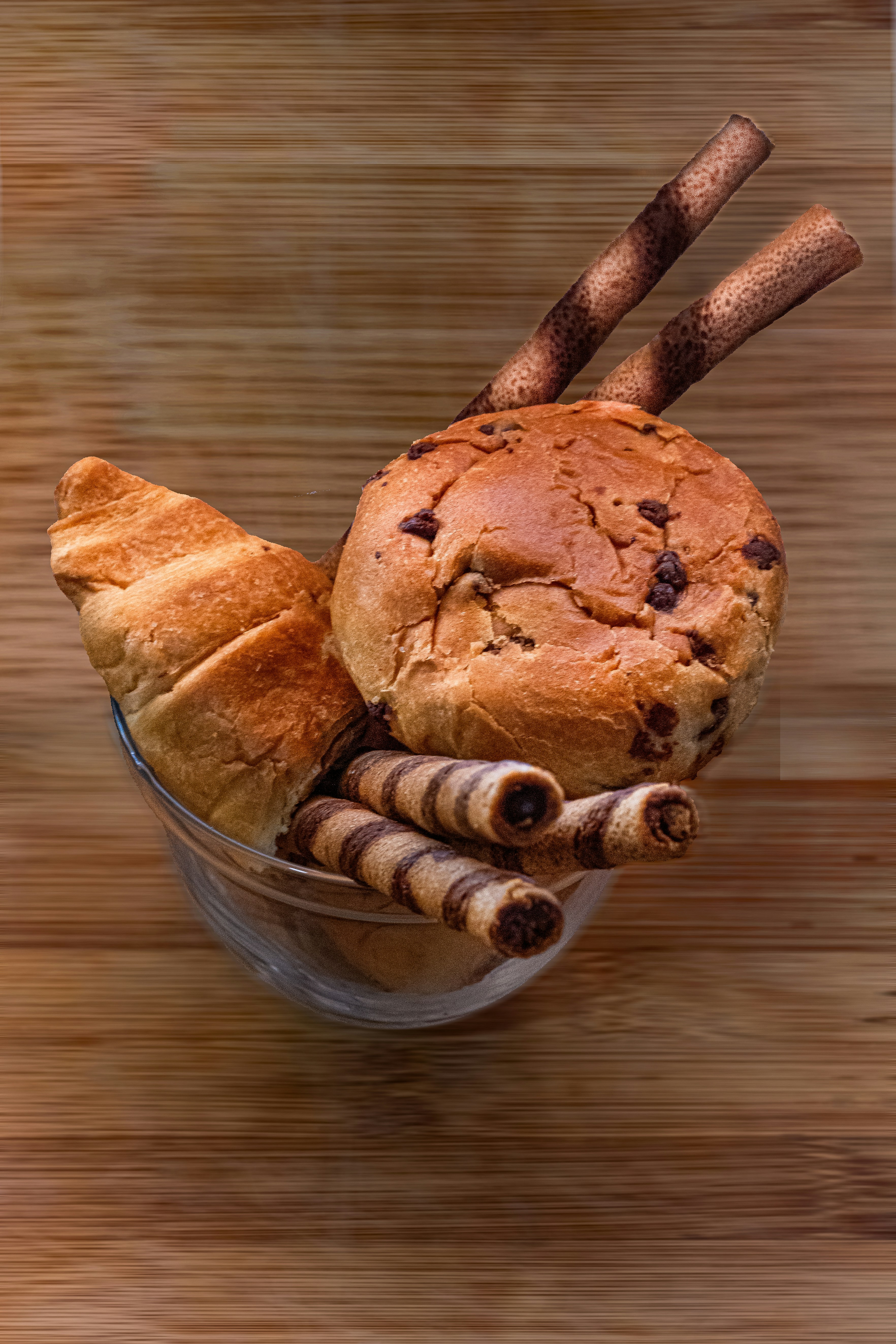A loaf of bread sitting in a bowl with cinnamon sticks sticking out of ...