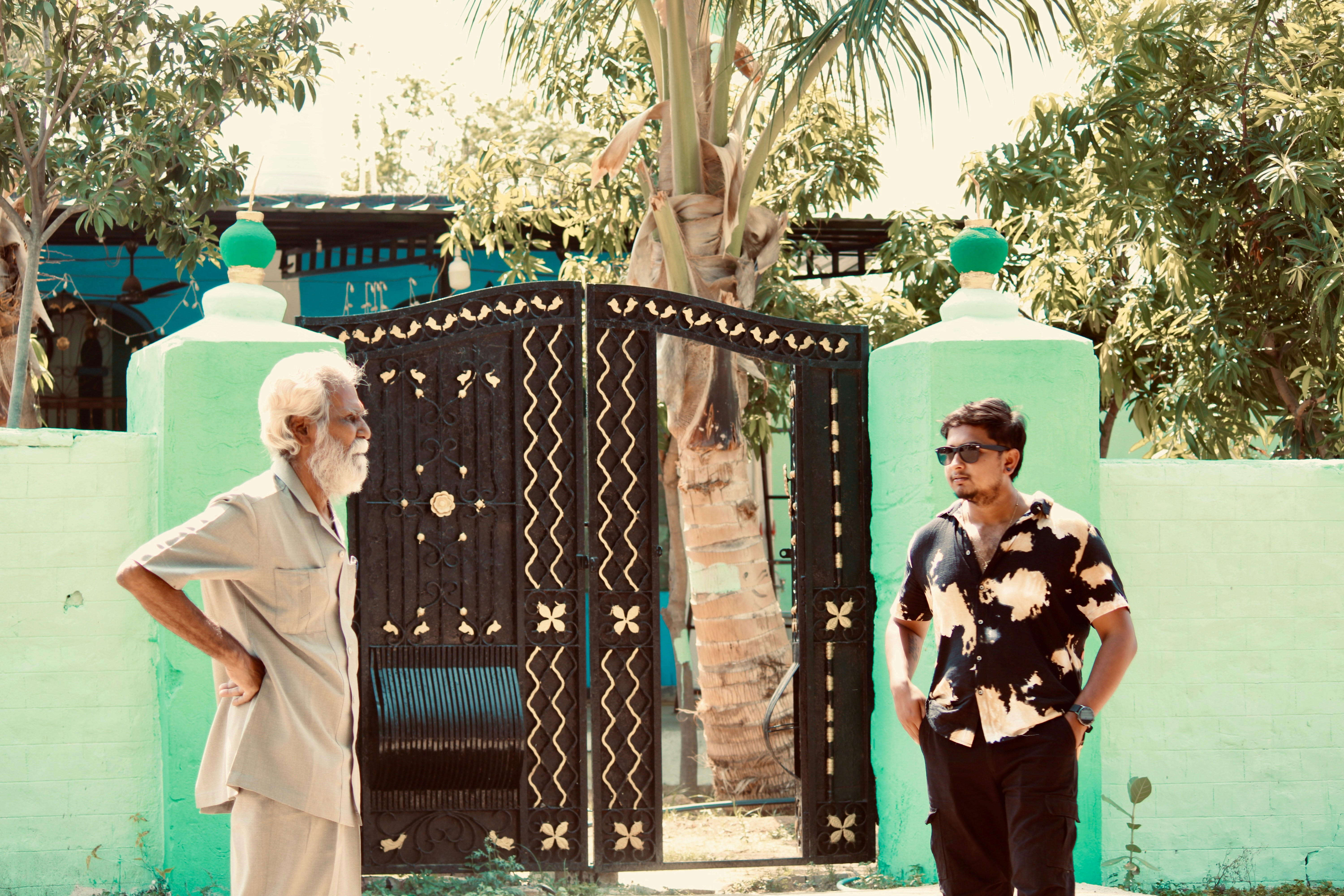 Two men standing in front of a gate photo – Free Man Image on Unsplash