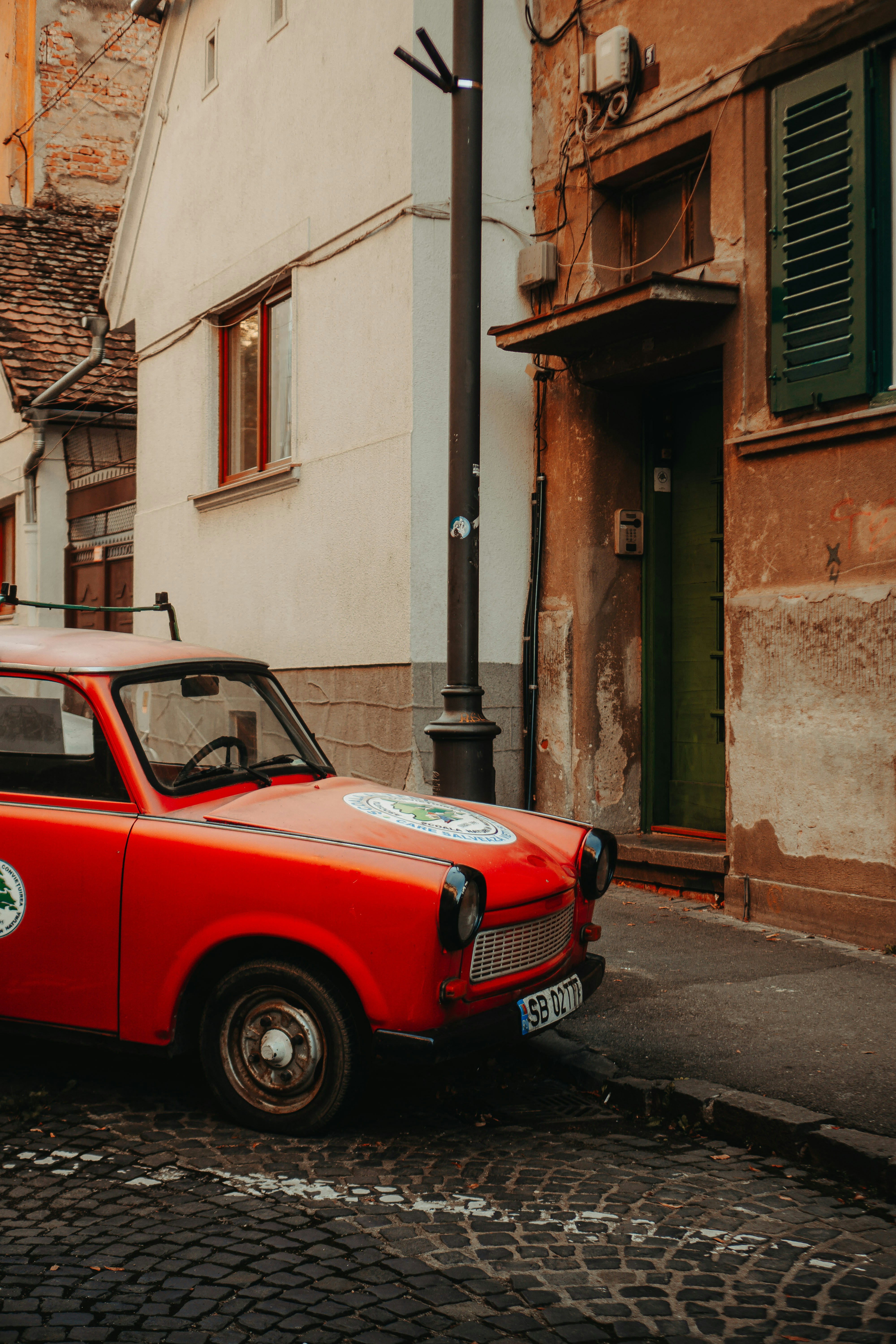 Foto zum Thema Ein kleines rotes Auto, das am Straßenrand geparkt ist ...