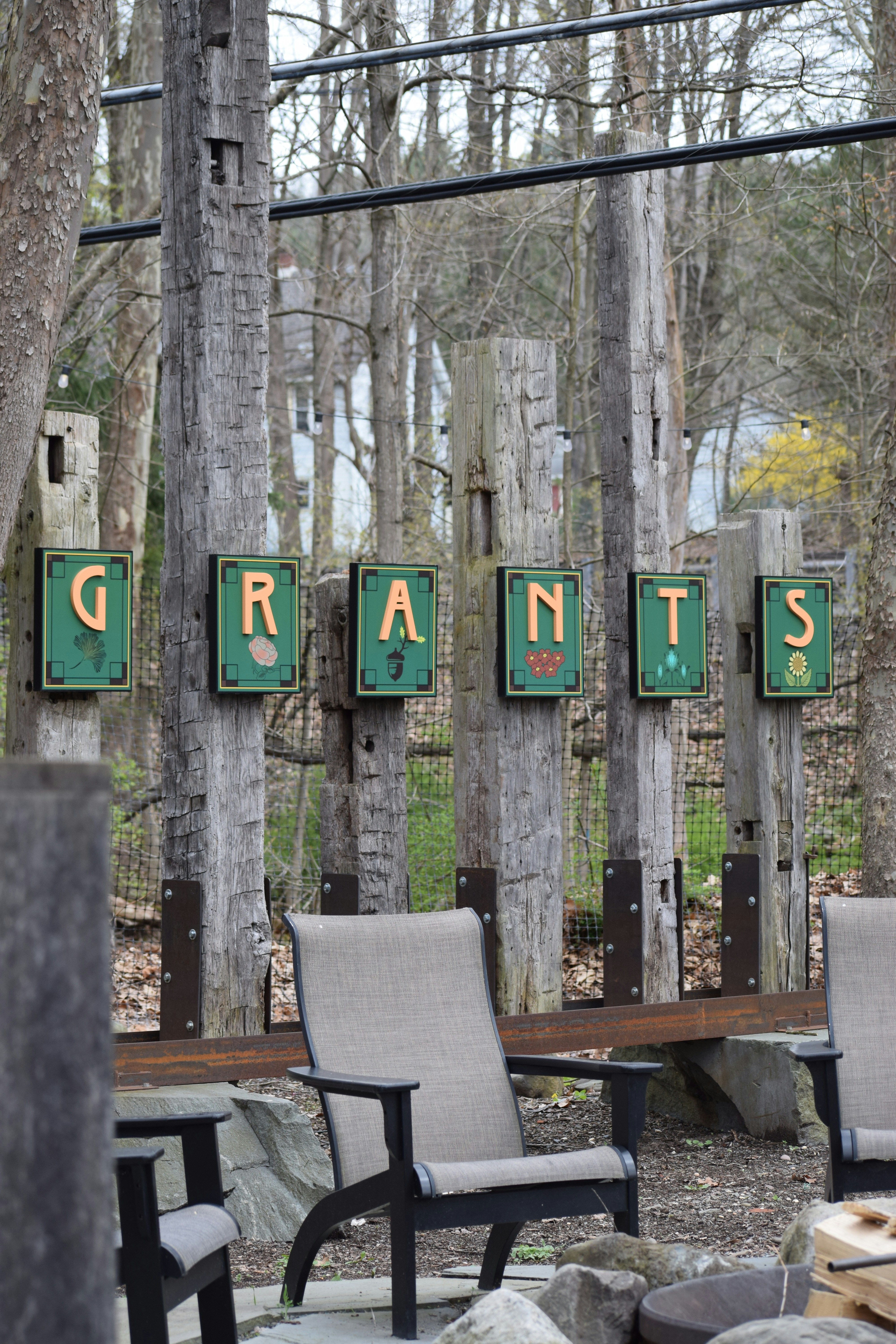 Green Letters on Weathered Posts: A Cozy Garden Seating Scene