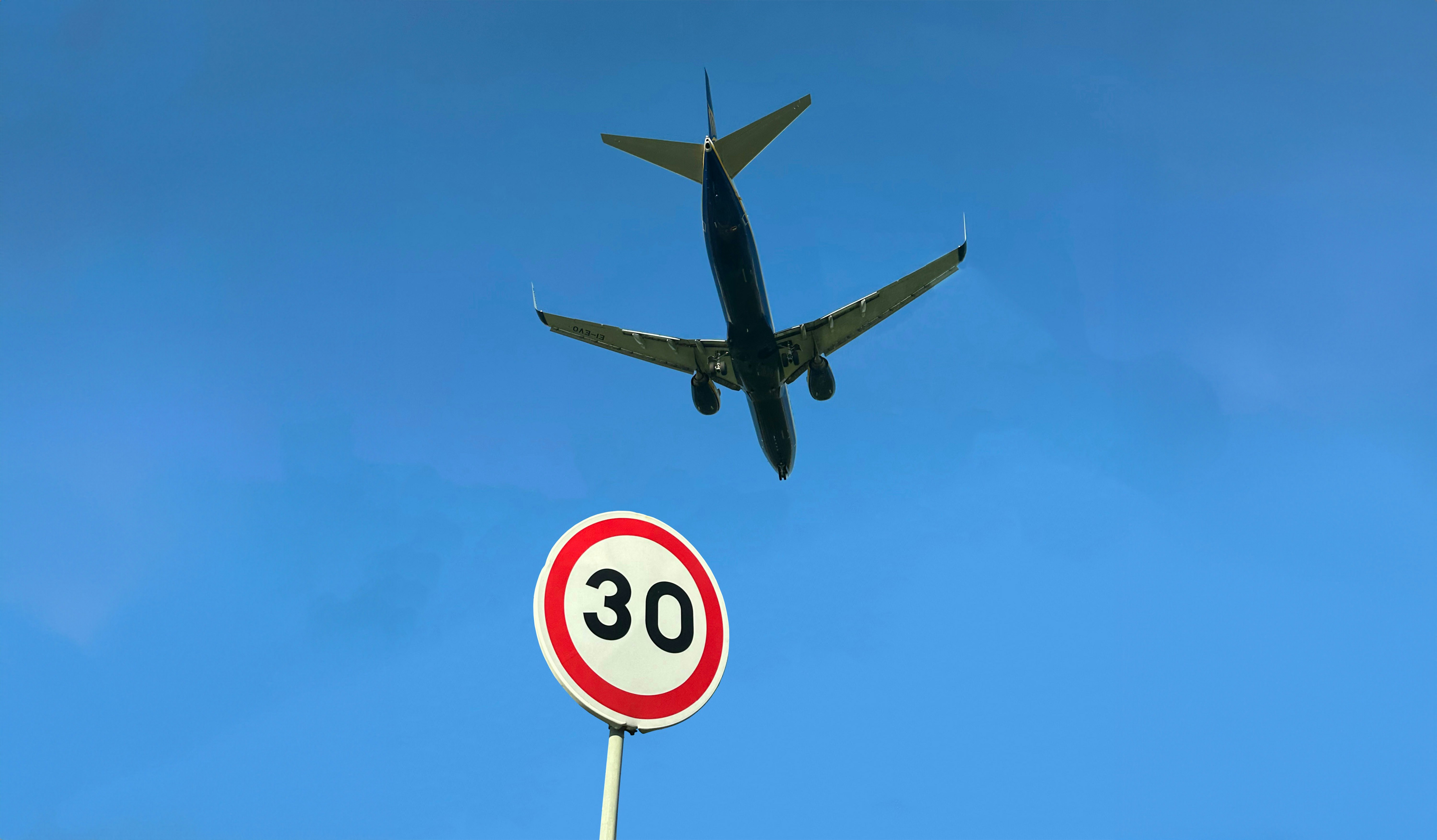 An airplane flying over a speed limit sign photo – Free Lisboa Image on ...