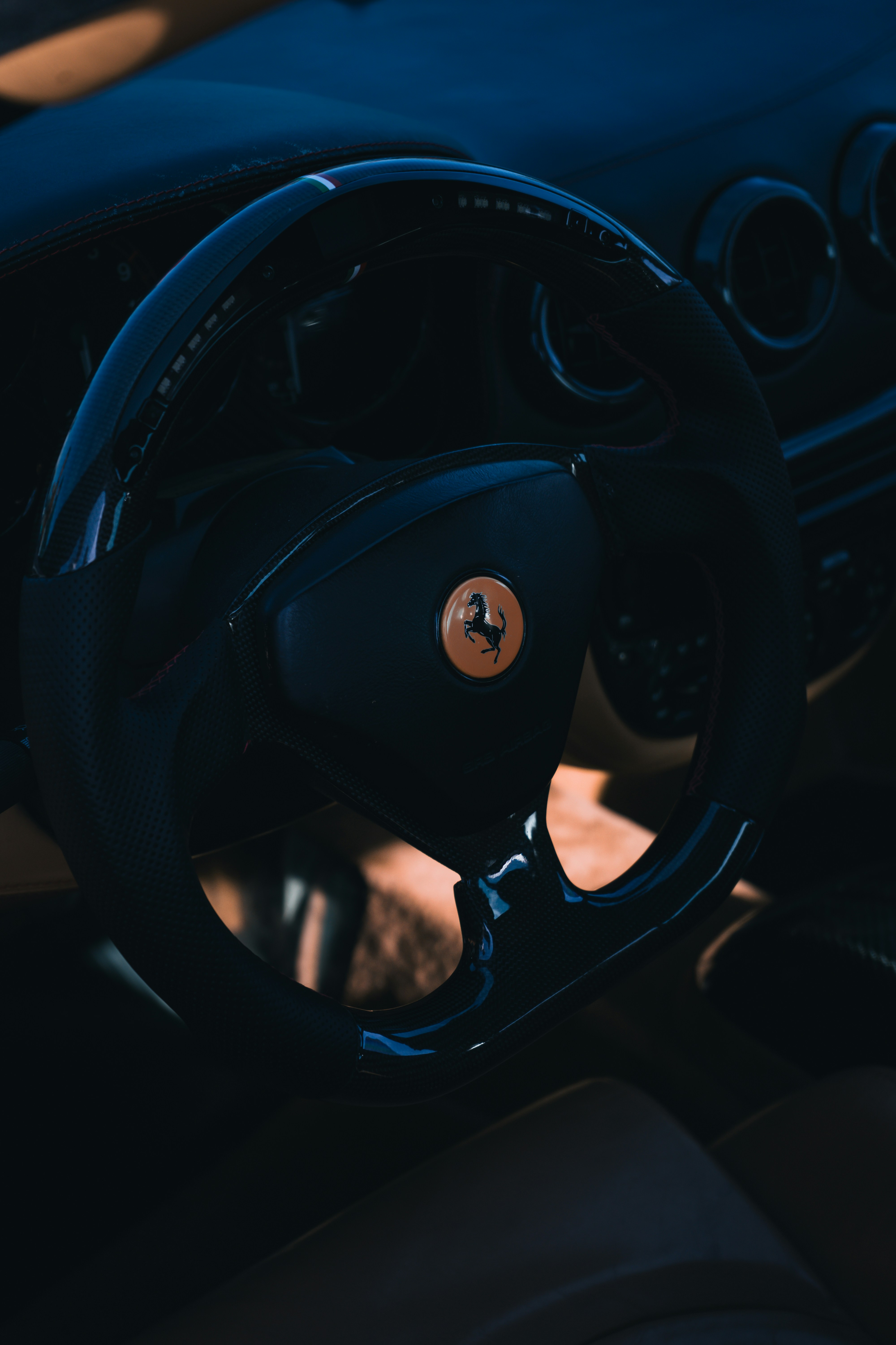Moody cockpit spotlight: Ferrari badge on the leather wheel