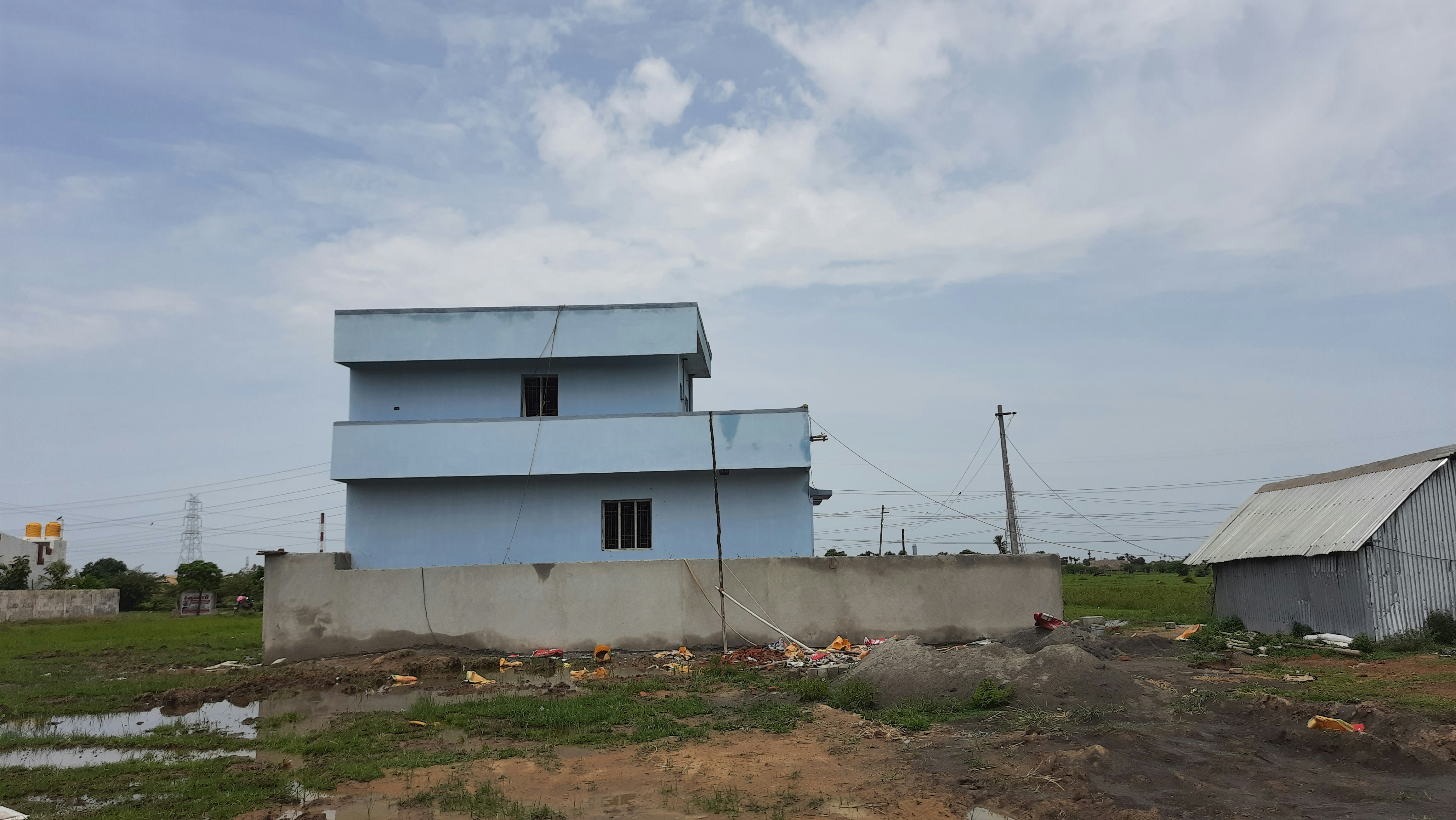 Stacked Blue Blockhouse Rising Over Mud and Open Sky