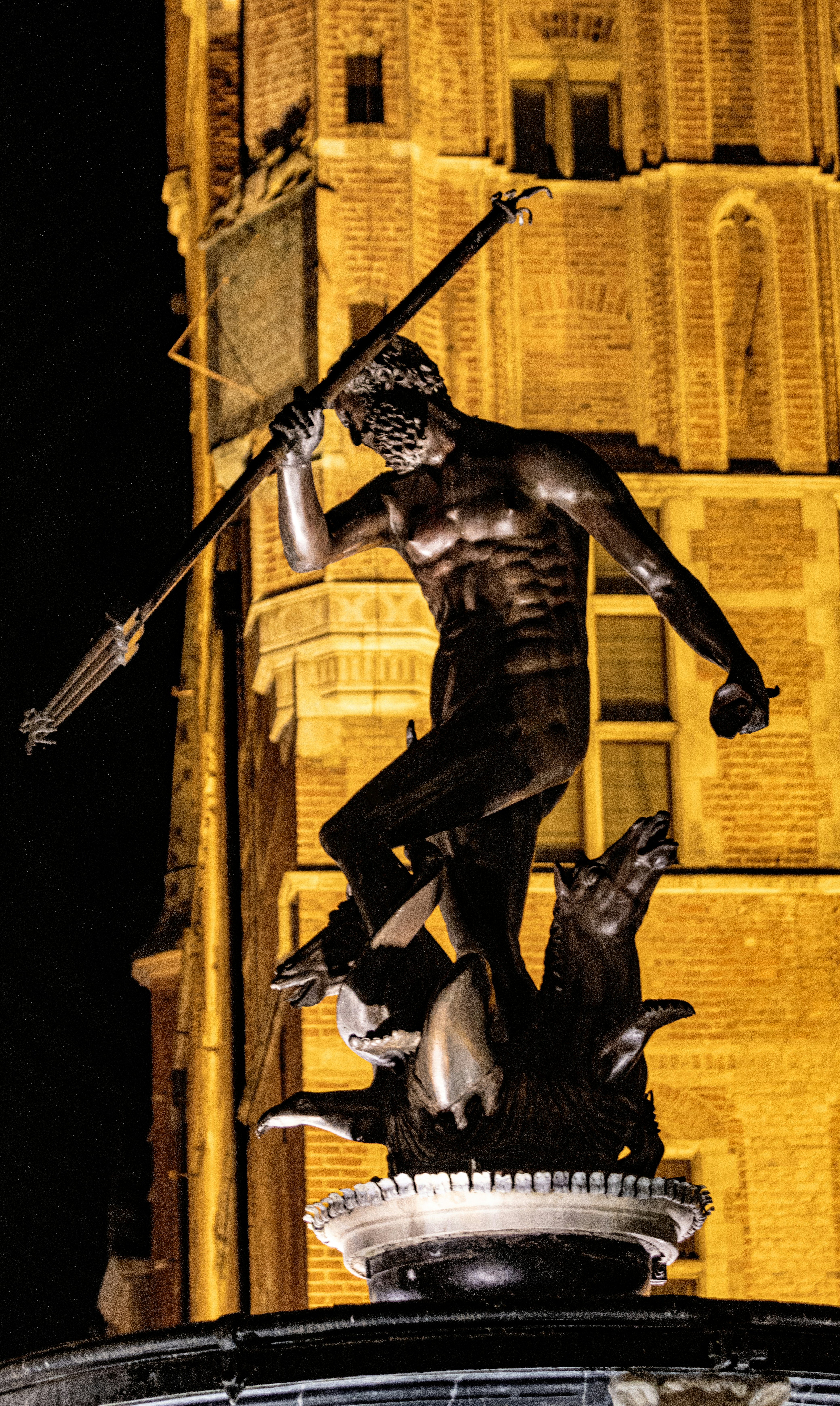 Night Sentinel: Bronze Warrior with a Spear Over a Dragon Fountain Against a Warm-Brick Backdrop