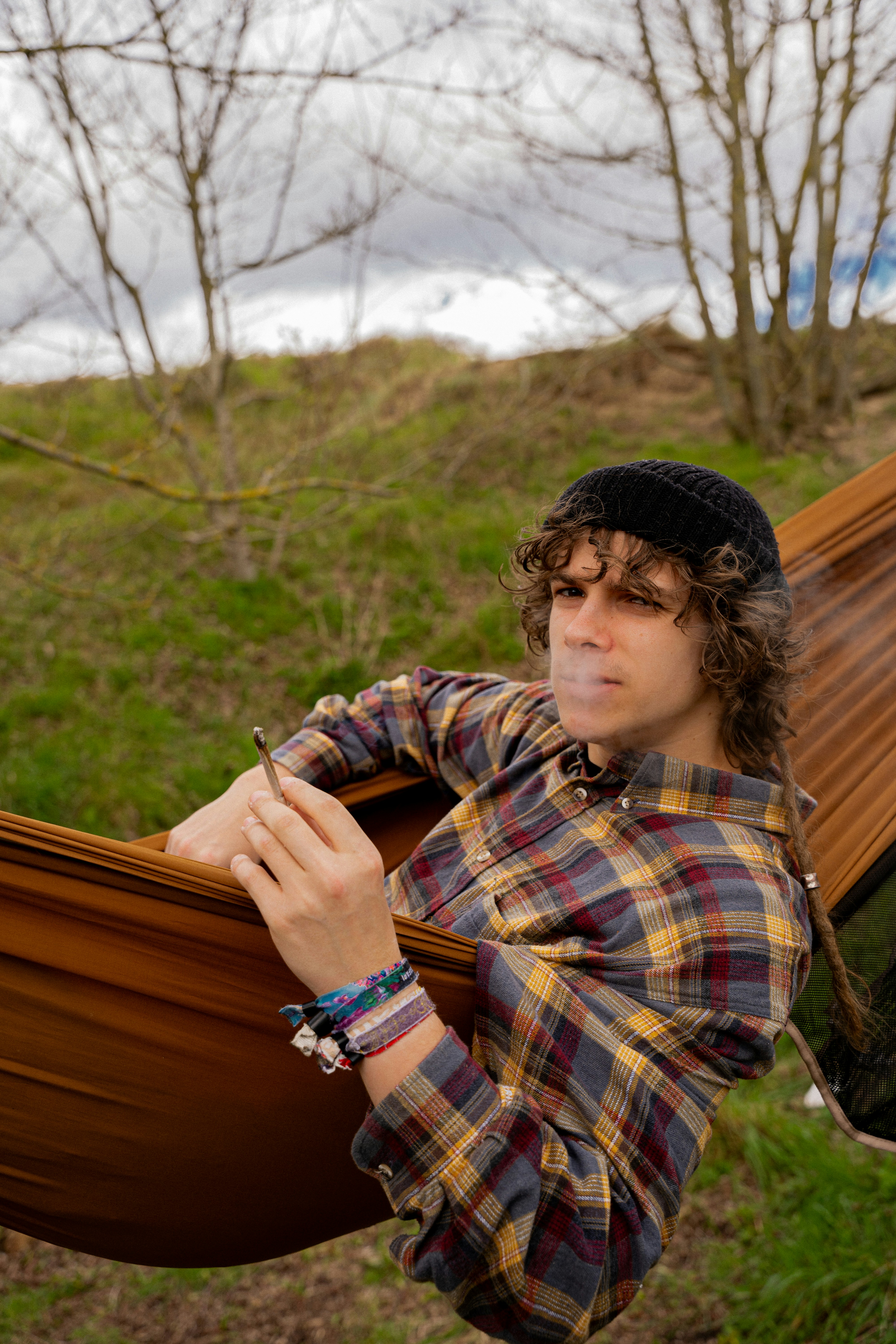 Hammock Moment: Quiet Portrait Amid Rustic Hills and Bare Trees