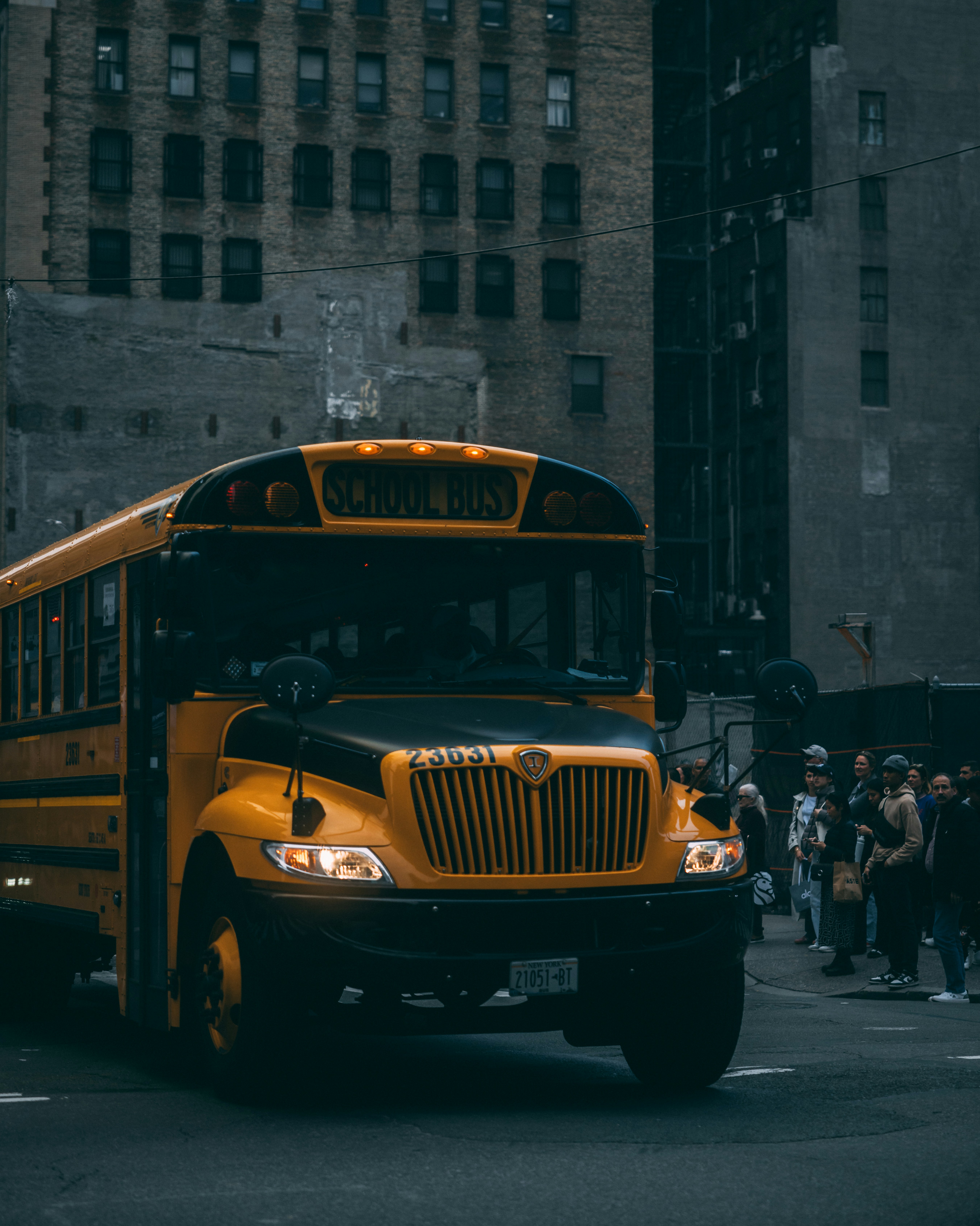 A yellow school bus driving down a city street photo – Free 5th avenue ...