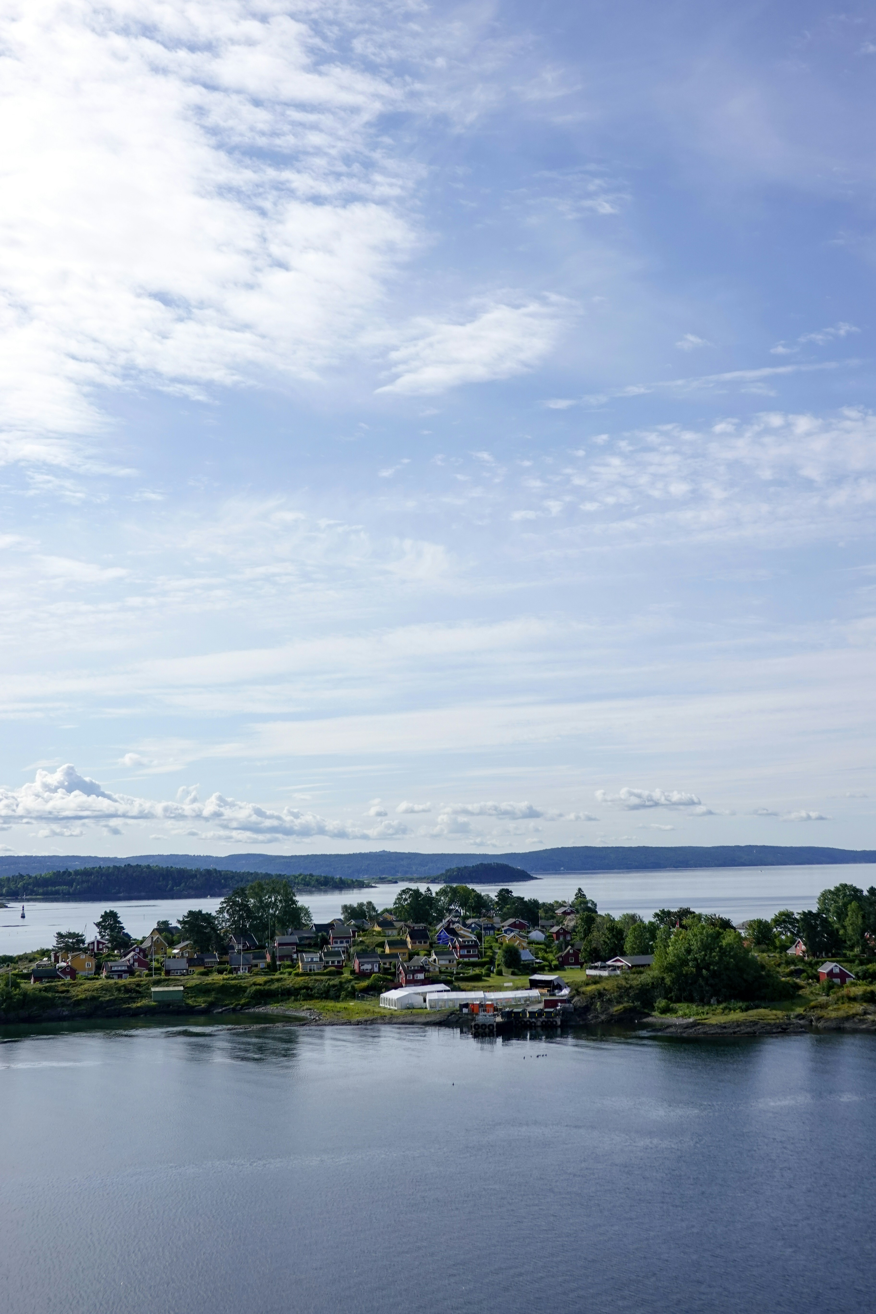 Harbor Village Along a Calm Inlet Under a Wide Blue Sky