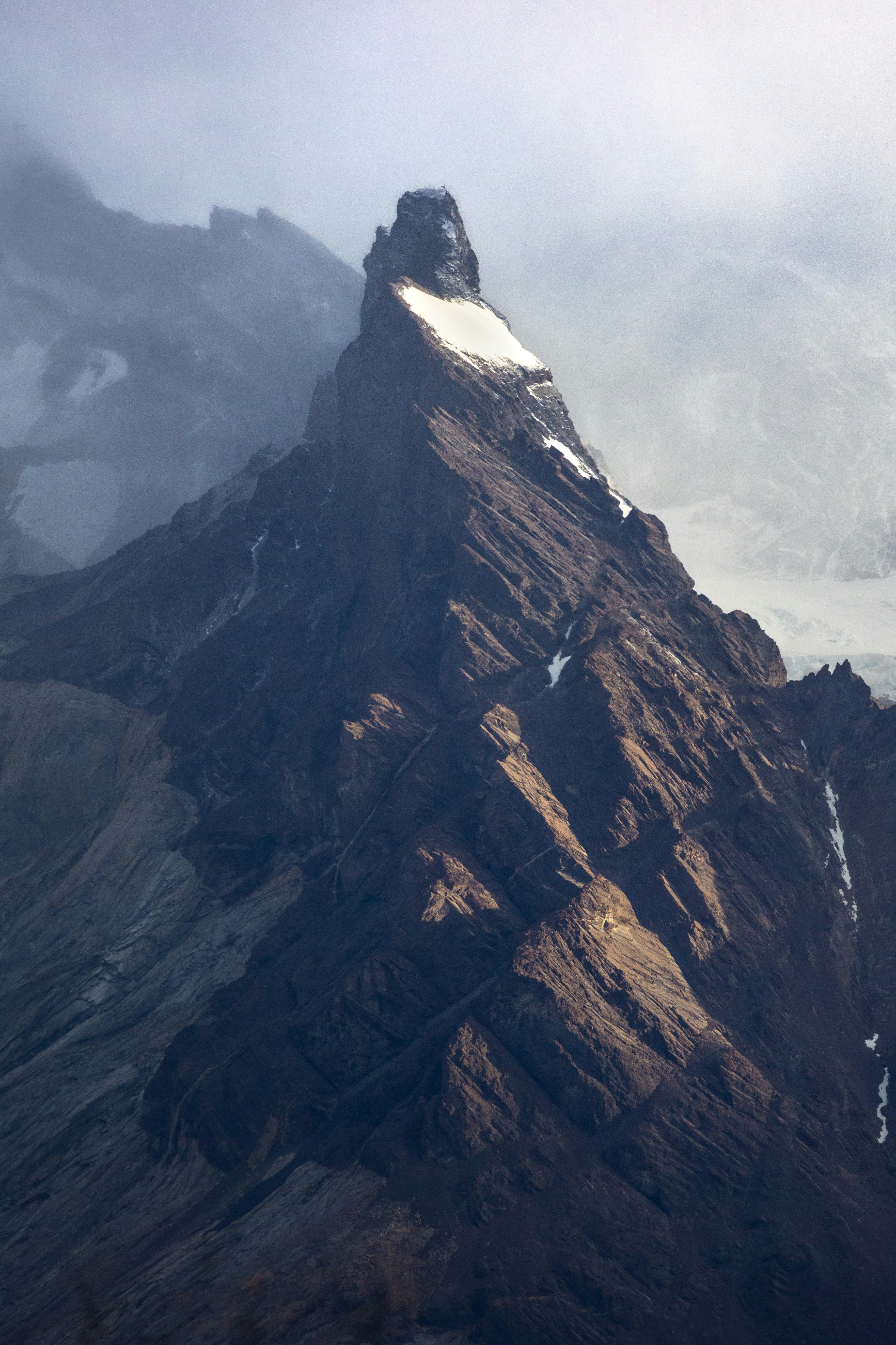 A very tall mountain covered in snow and clouds photo – Free Nature ...