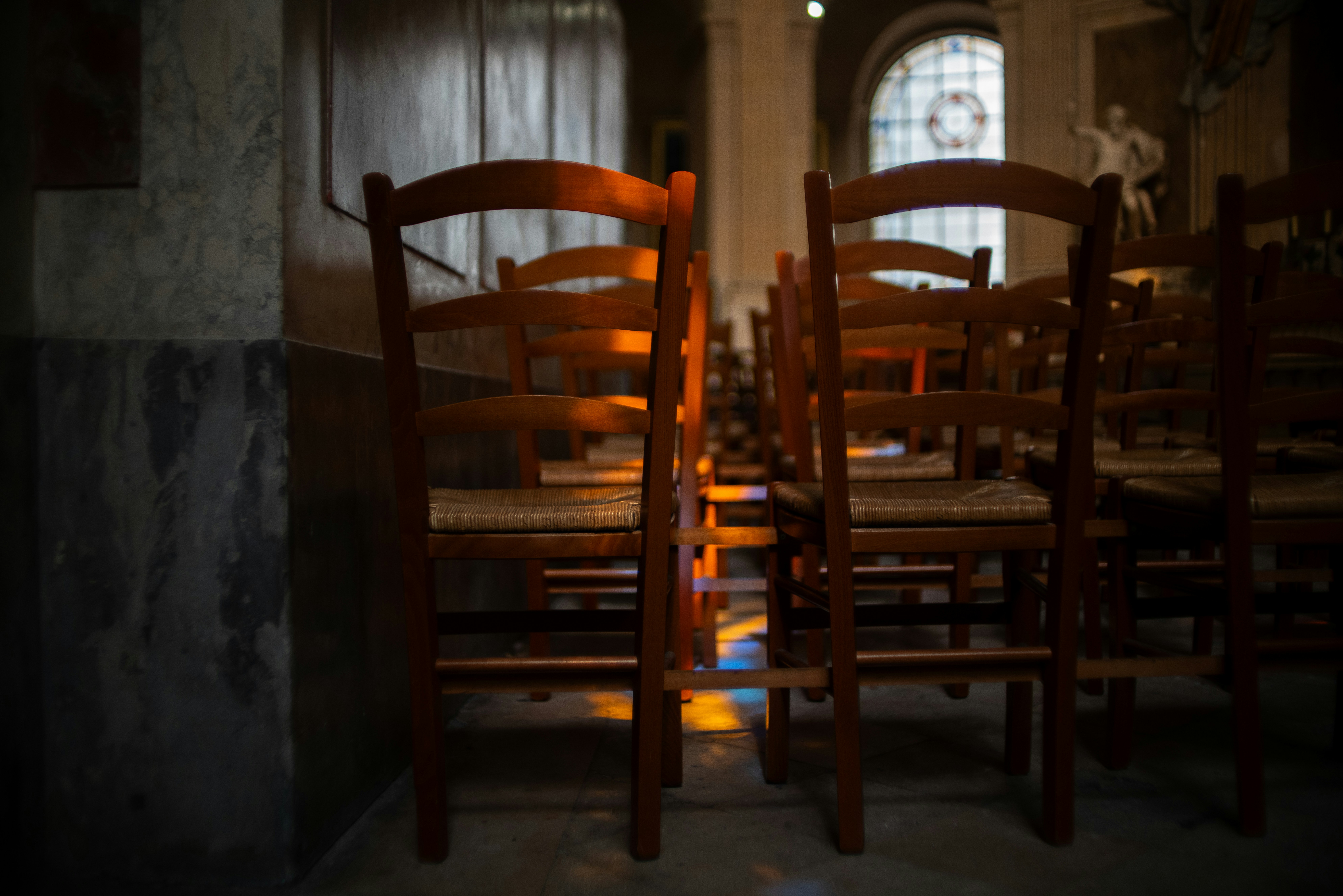 Amber Rows in a Quiet Chapel: Wooden Chairs Await the Quiet