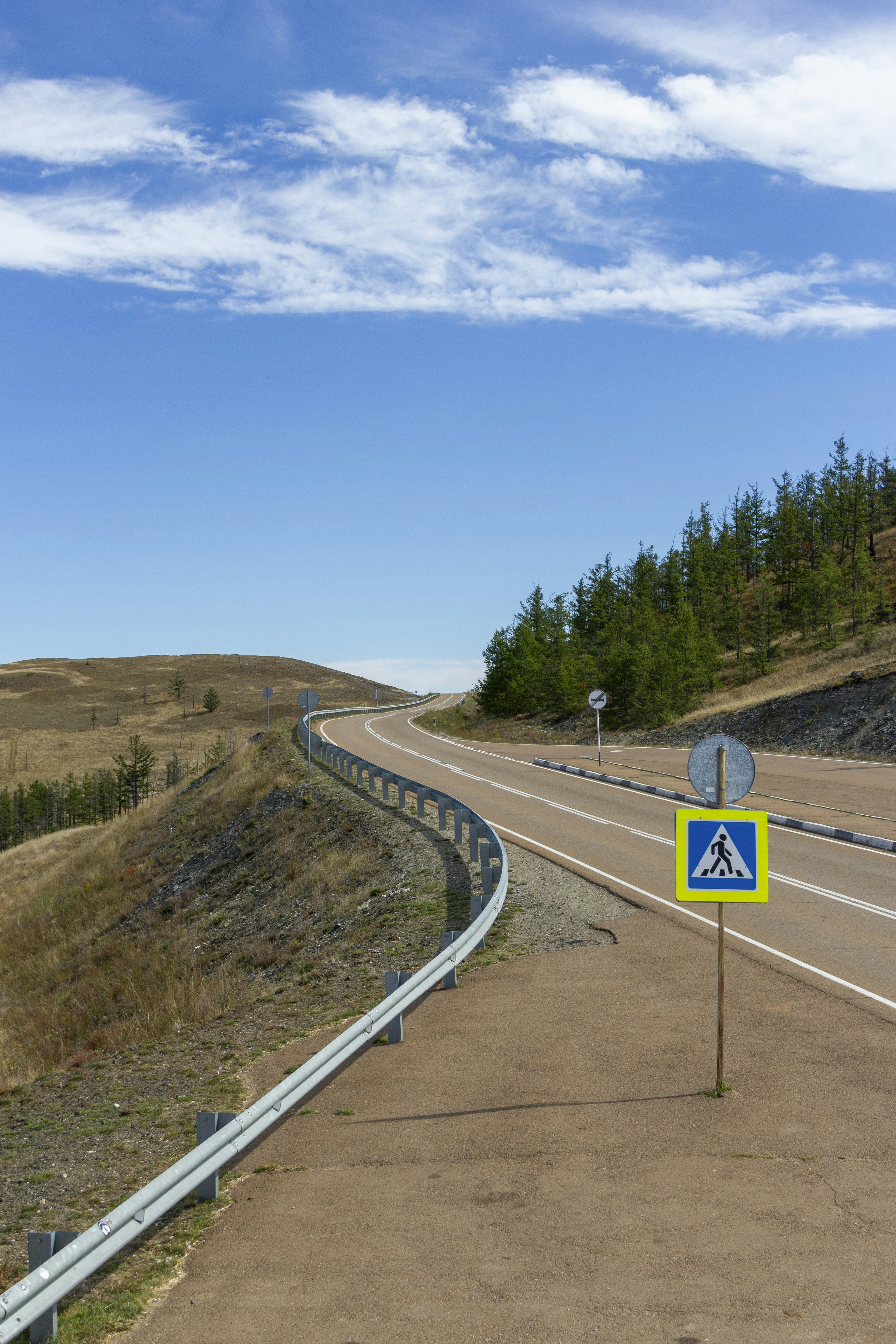 Winding Hill Road and the Lone Pedestrian Sign under a Clear Blue Sky