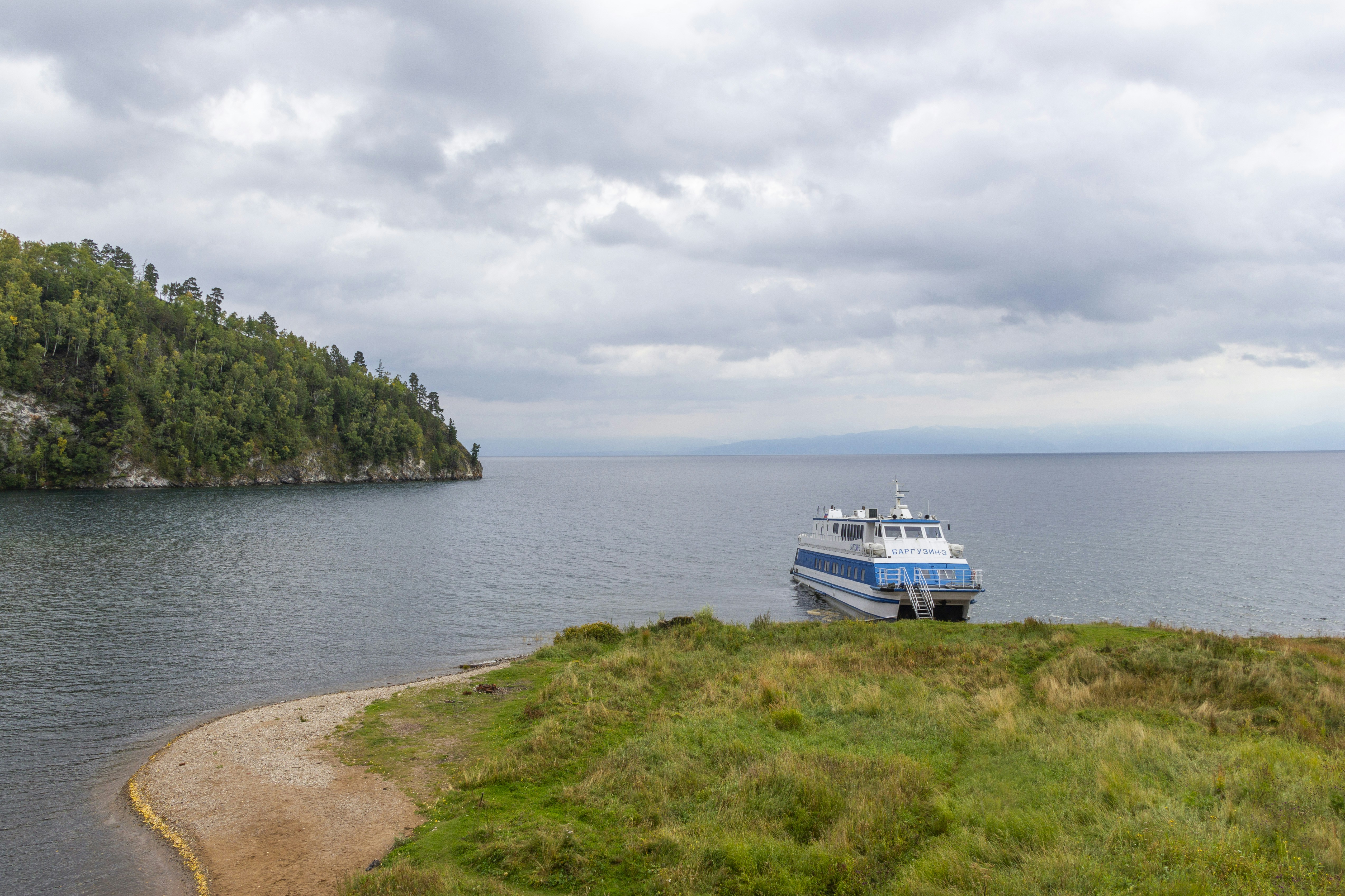 Blue Boat at the Edge: A Quiet Cove Framed by Grass and Cliff