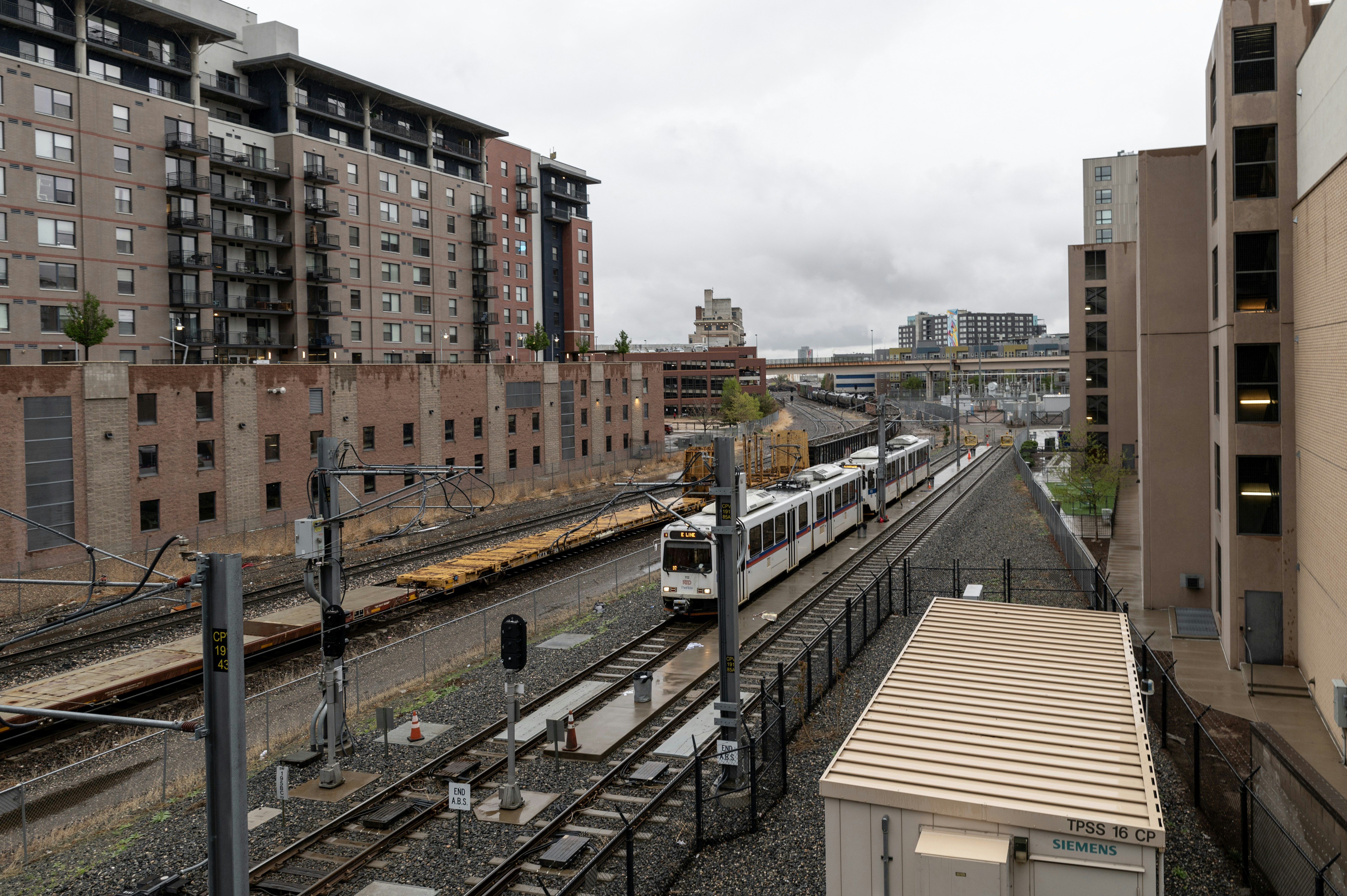 A train traveling down train tracks next to tall buildings photo – Free ...