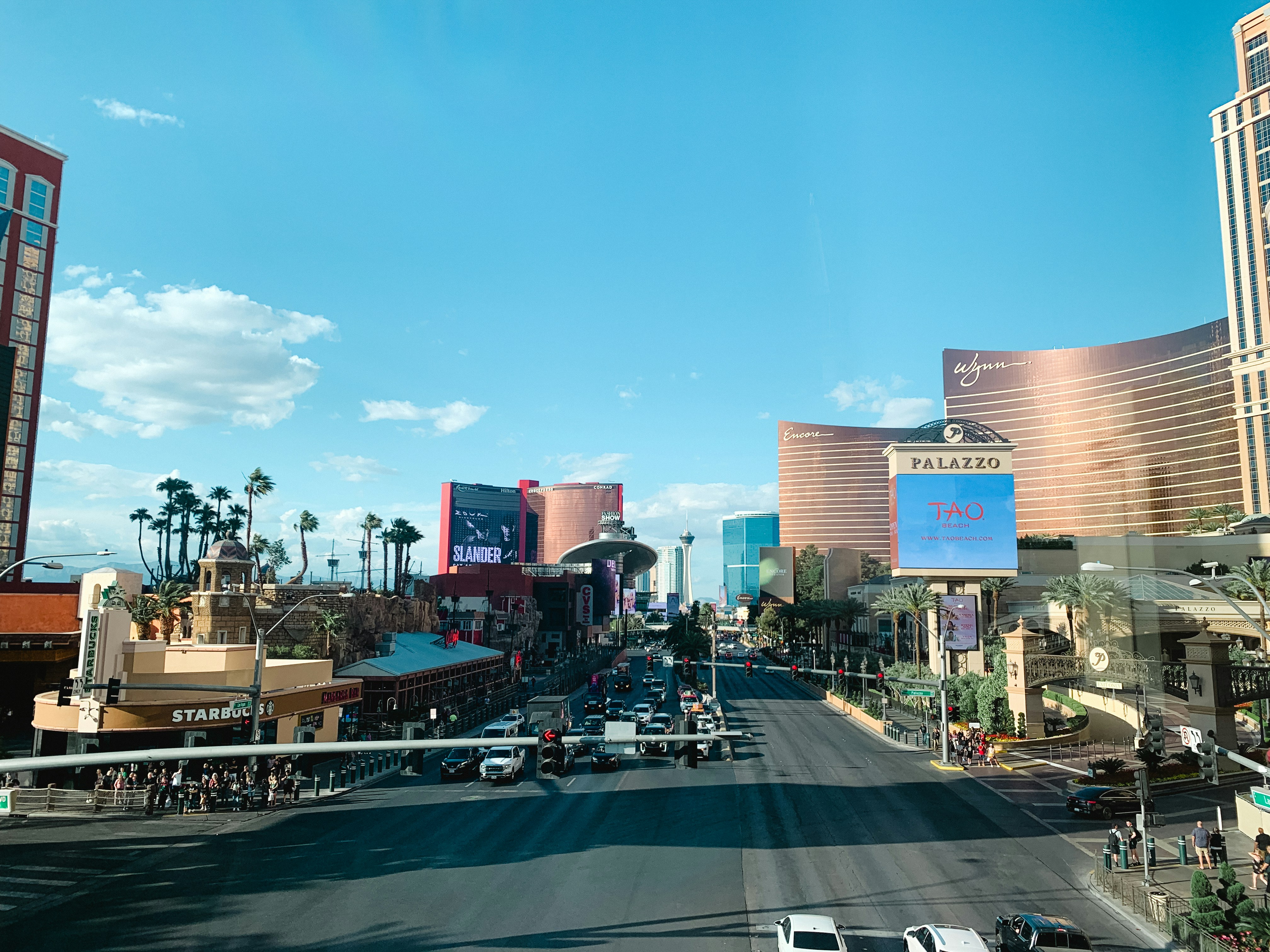 Bustling city street with heavy traffic surrounded by towering modern buildings under a clear blue sky.