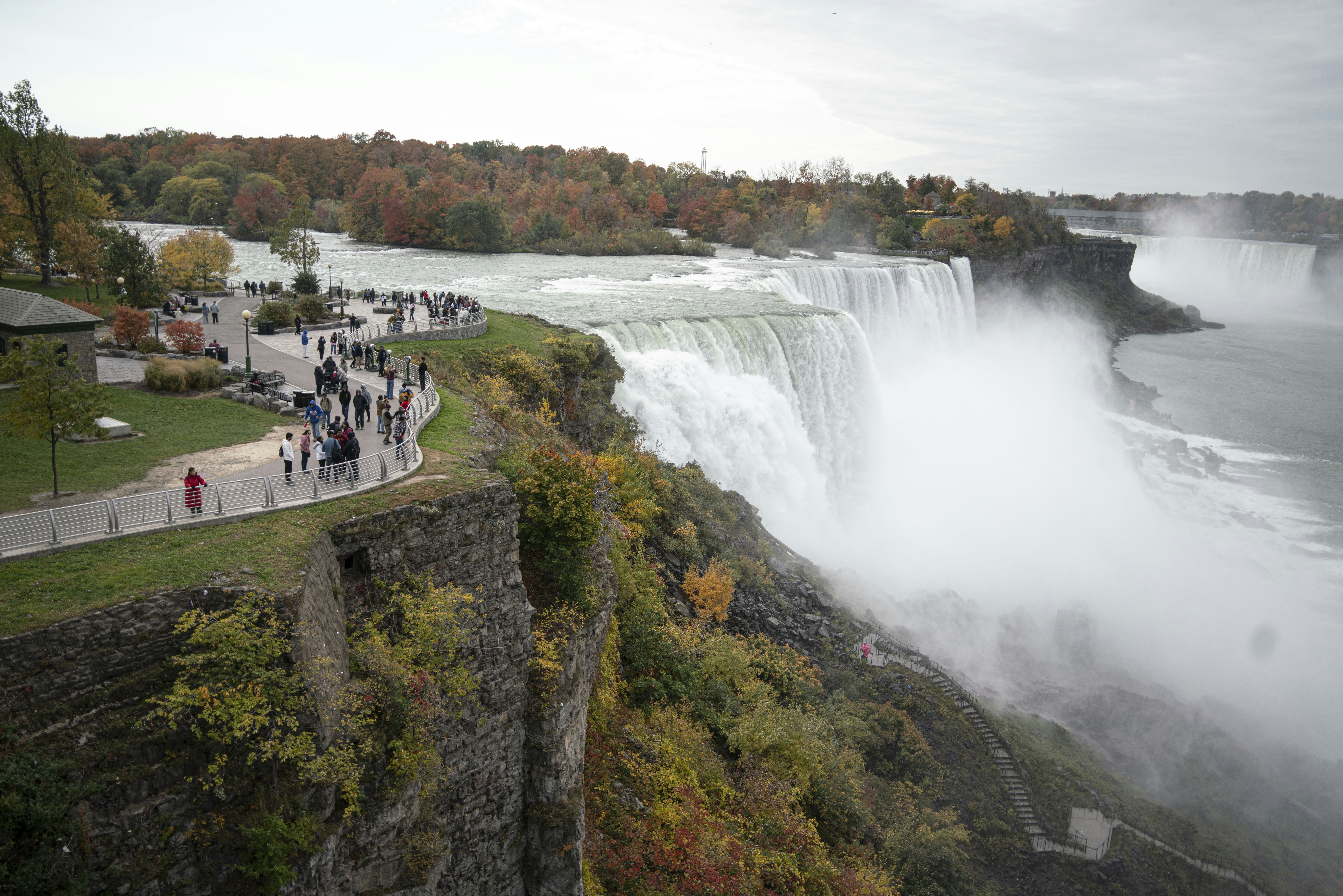 a group of people standing on the side of a waterfall