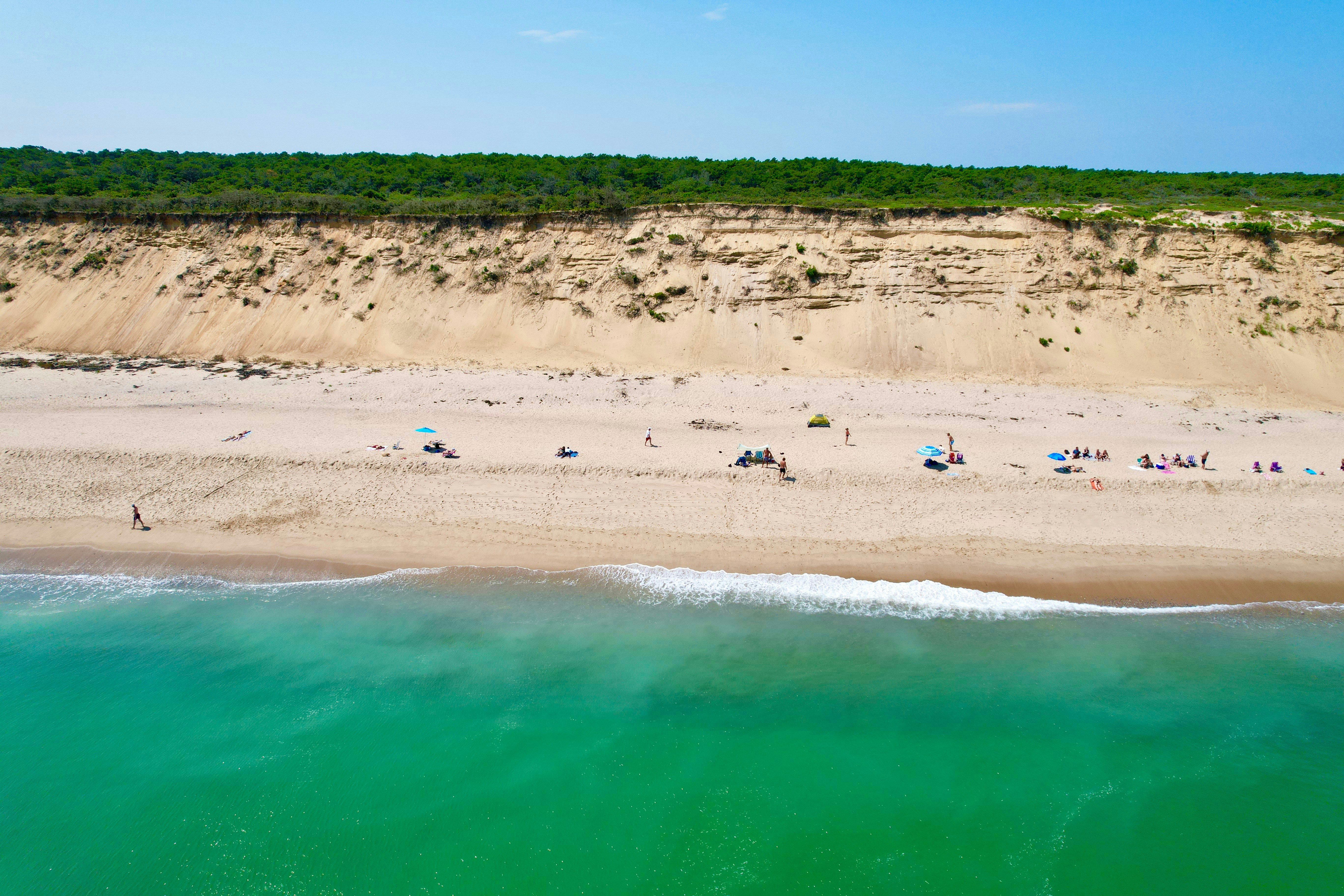 An aerial view of a beach with people and umbrellas photo – Free ...