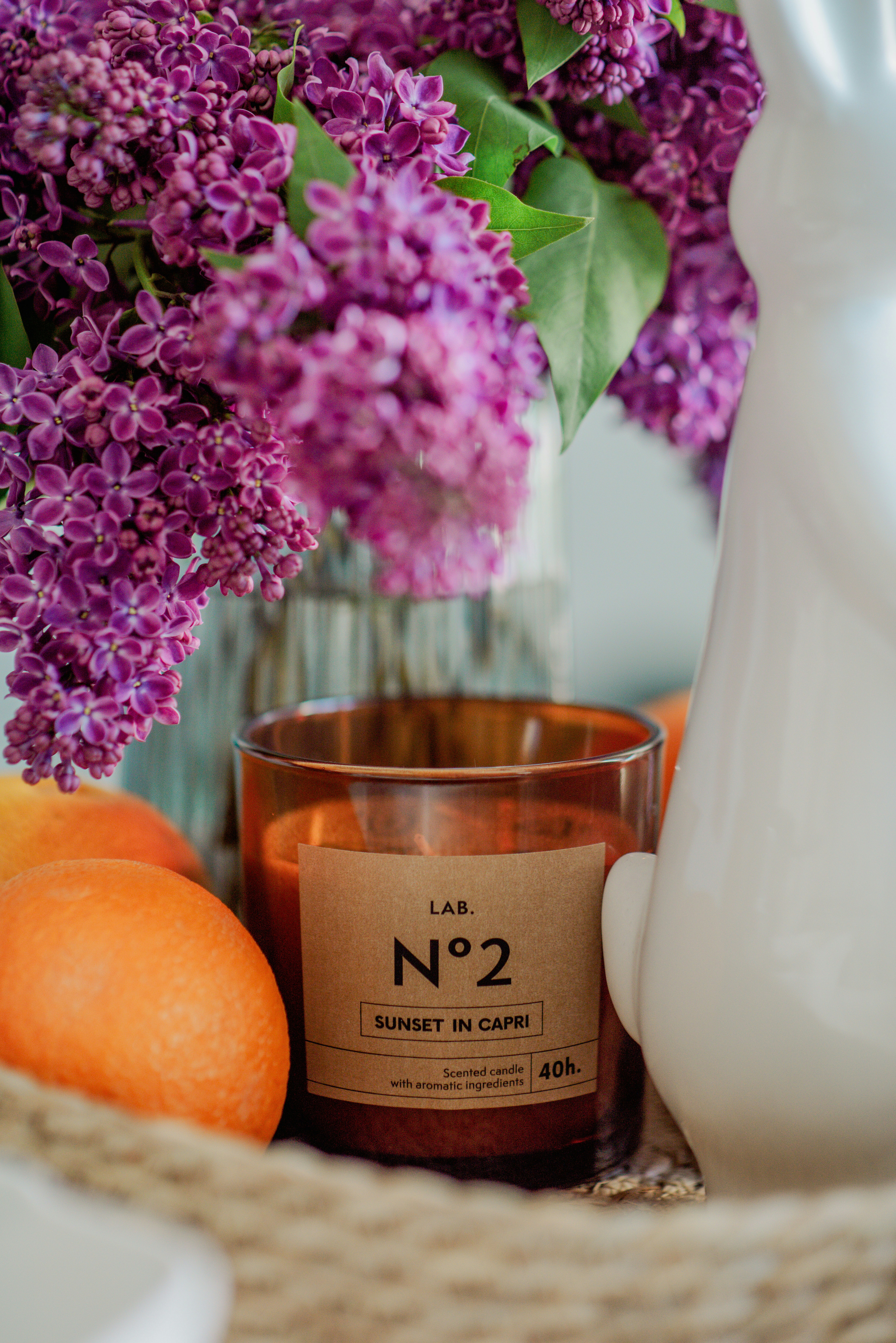 Lilac Still Life: A Candle, Citrus, and Bloom in Soft Focus