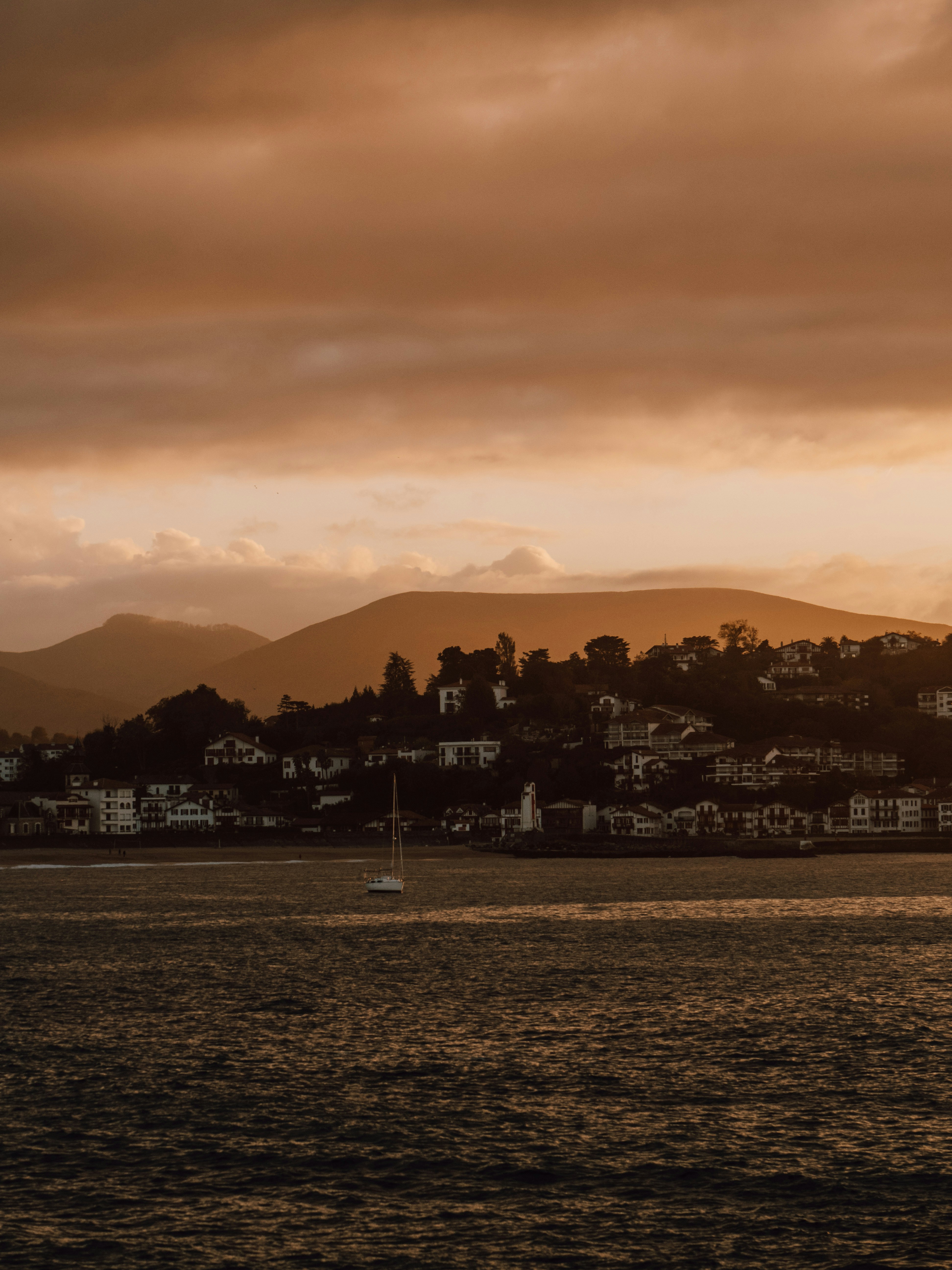Sepia-tinted Dusk: A solitary sailboat gliding over a hushed bay