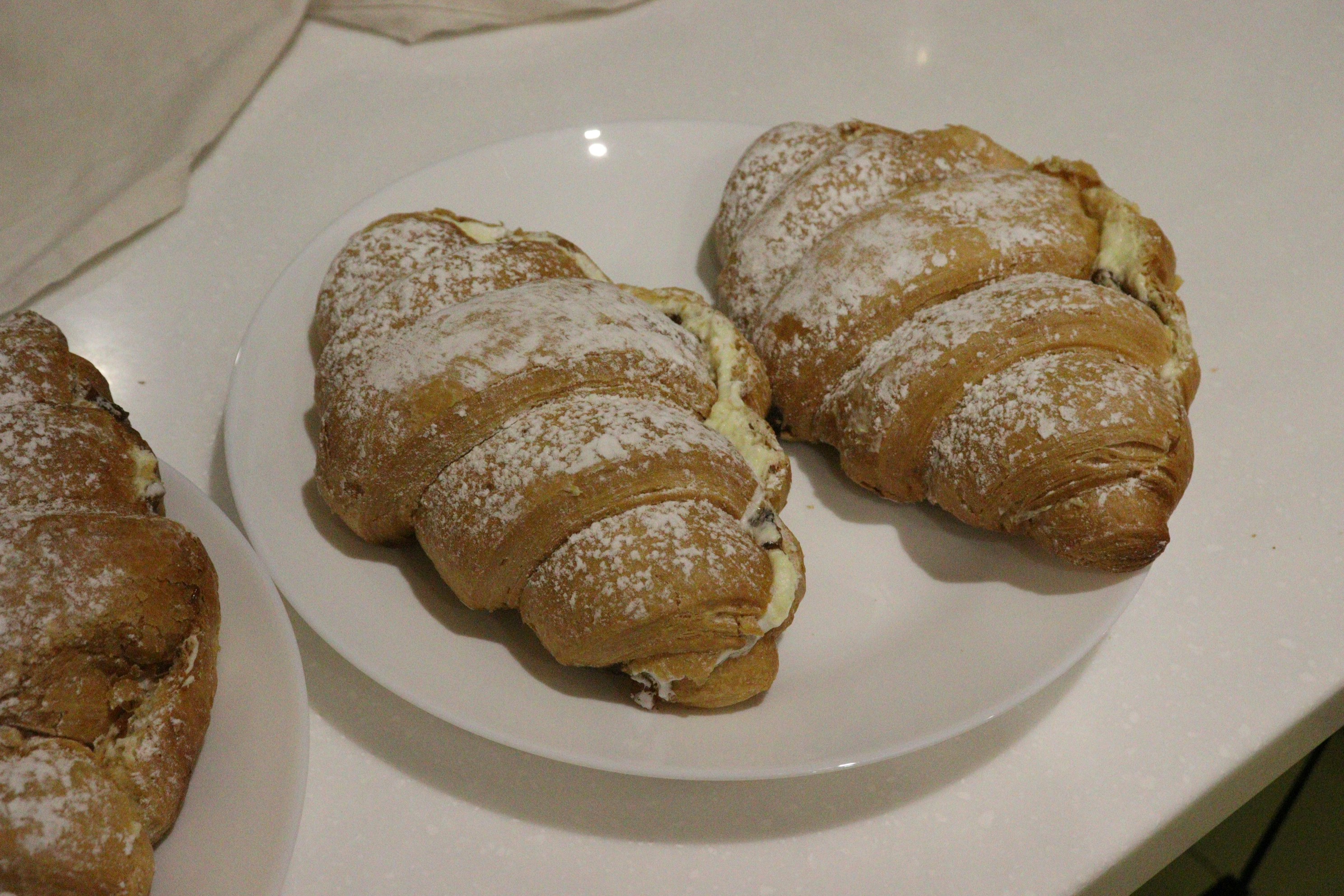 A white plate topped with croissants covered in powdered sugar photo ...