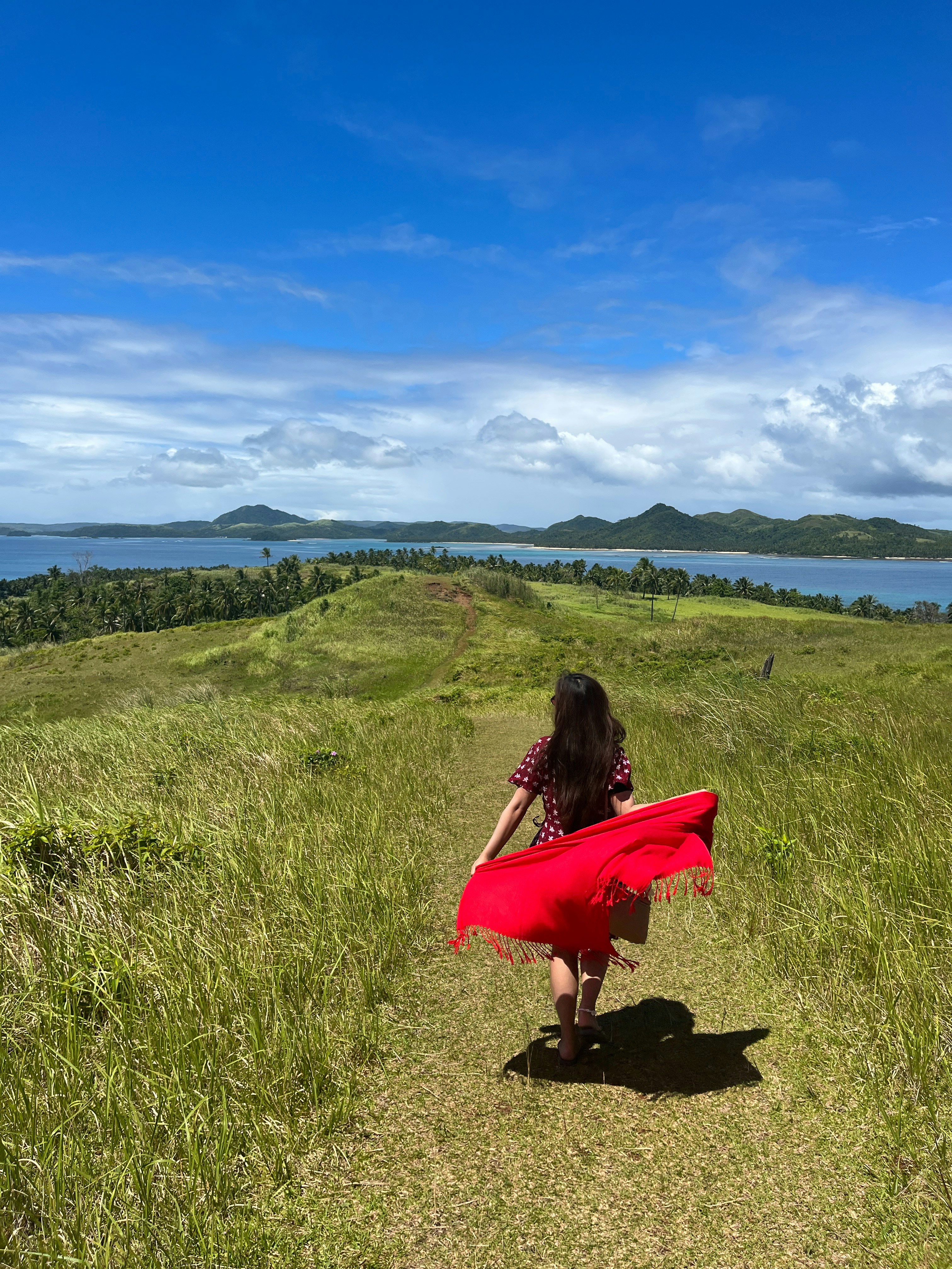 Scarlet Cloak on a Wind-Kissed Trail to the Coastal Horizon