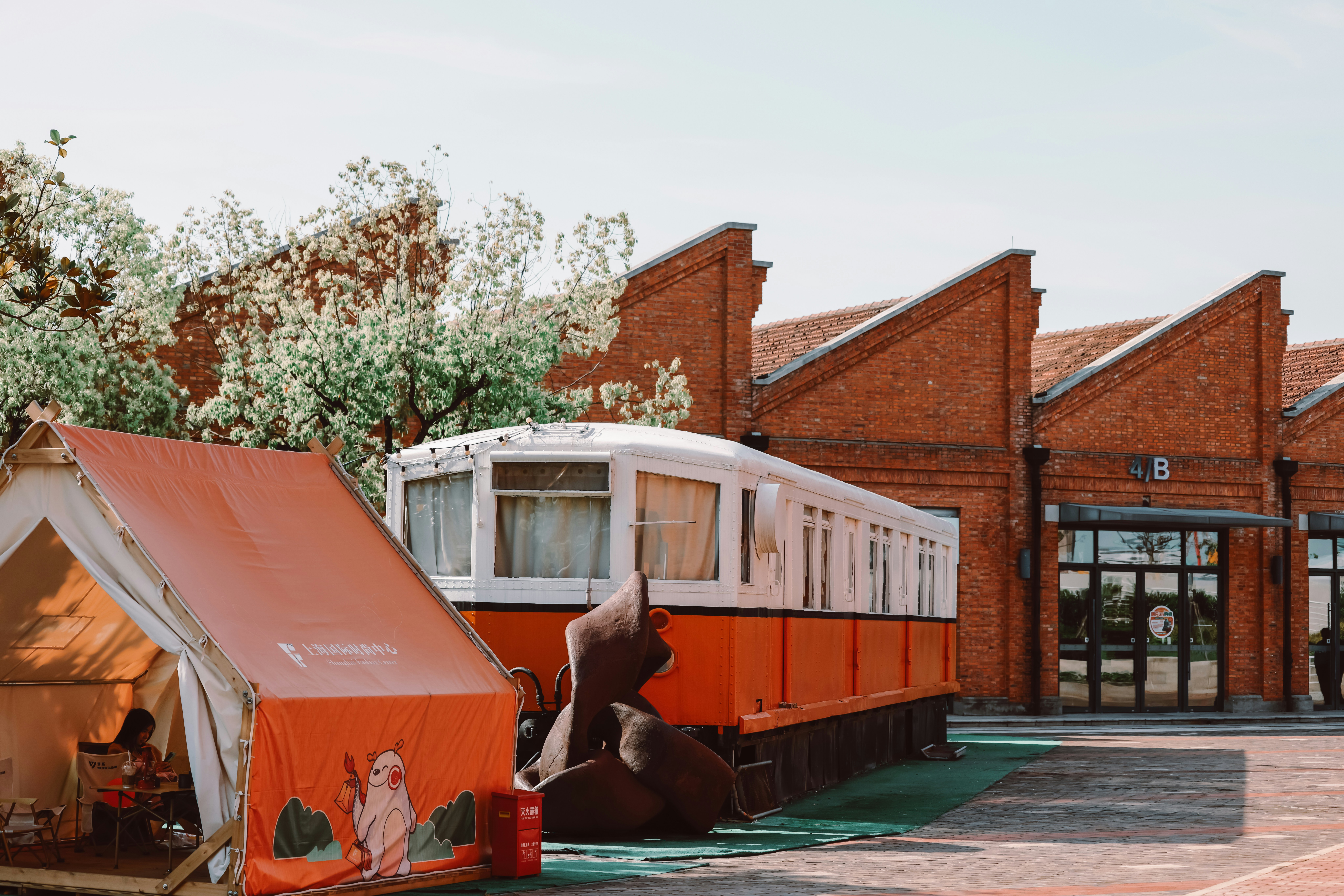 Orange Caravan by the Brick Courtyard: A Quiet Street Tableau