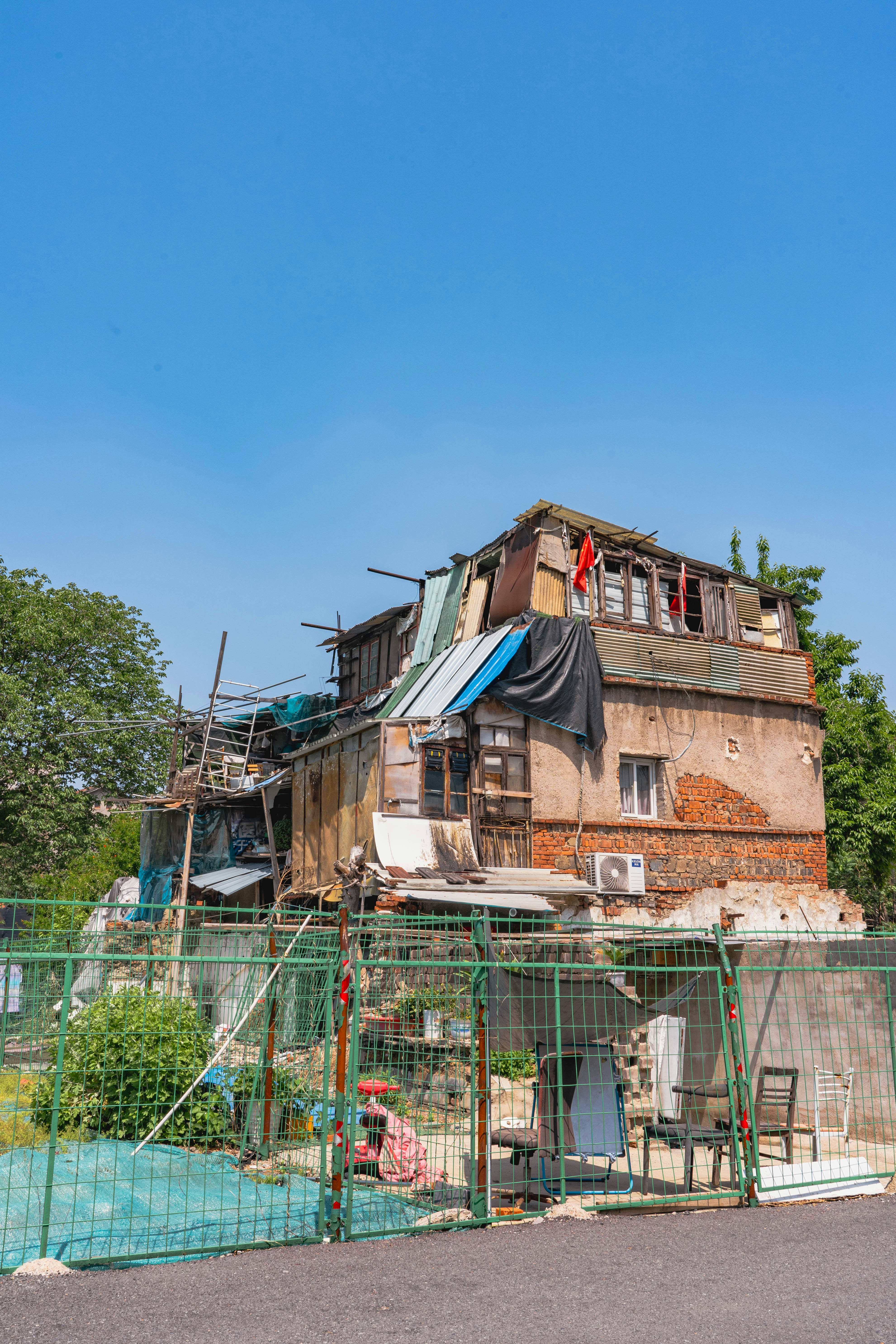 An old building with a lot of junk on top of it photo – Free ...