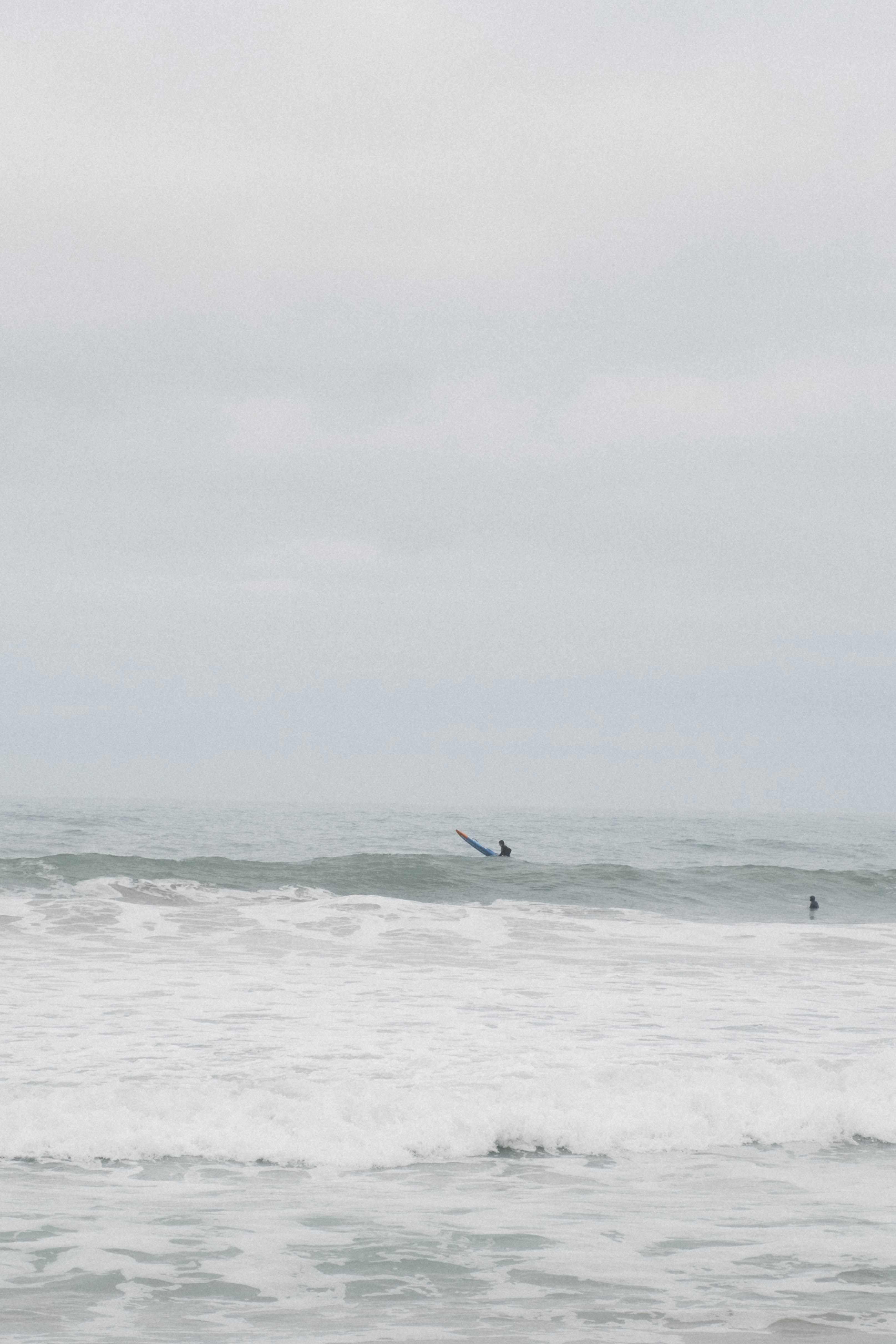 A person riding a surfboard on a wave in the ocean photo – Free Grey ...