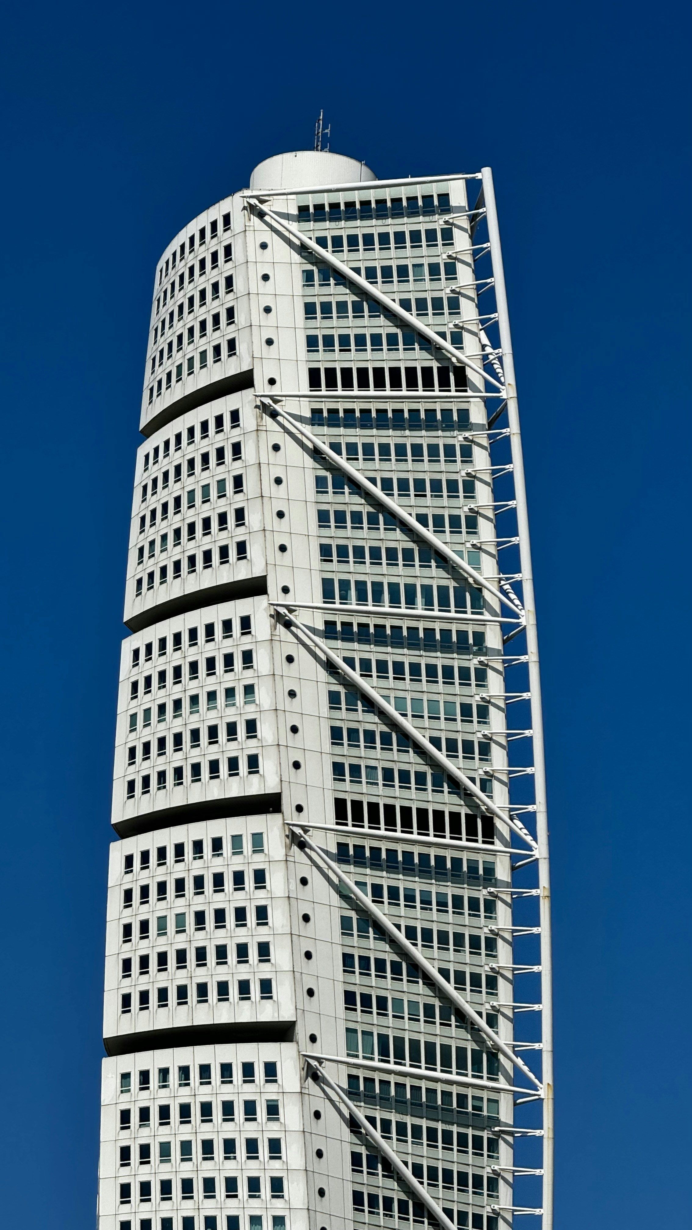 Crisscrossed Braces Elevate a White Tower Against a Pristine Blue Sky