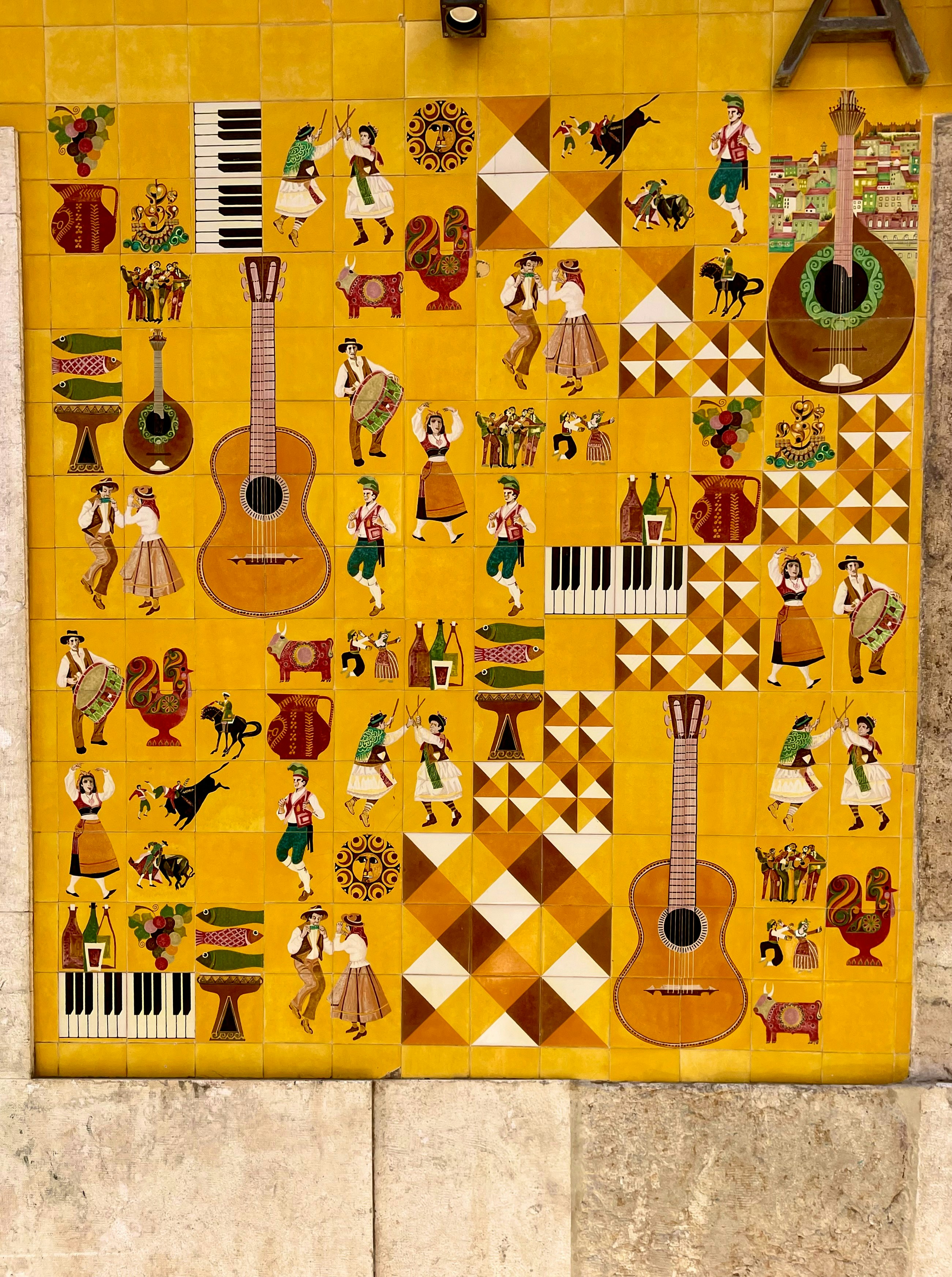 A yellow tile wall with a guitar and musical instruments on it photo ...