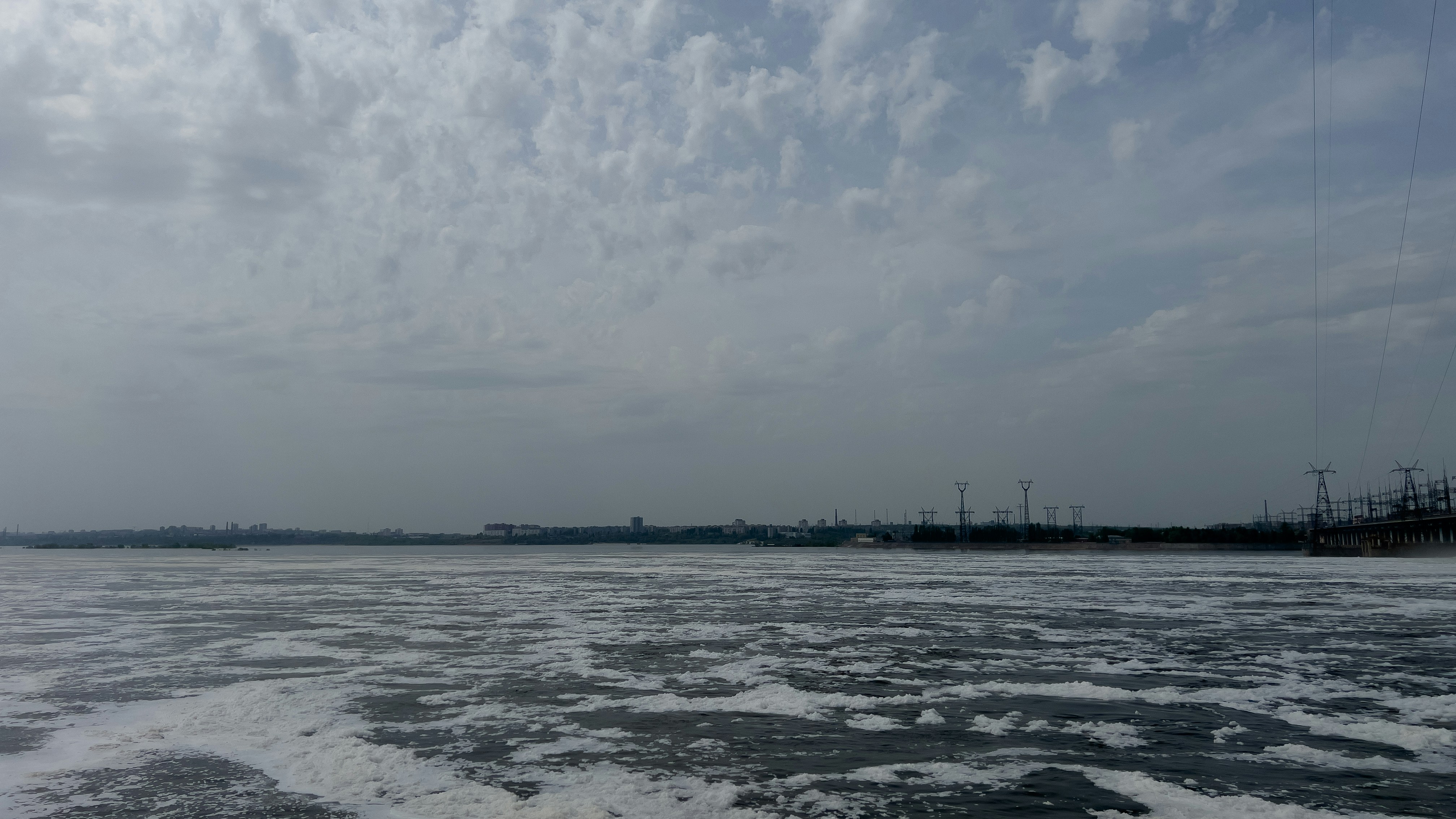 a large body of water with a bridge in the background