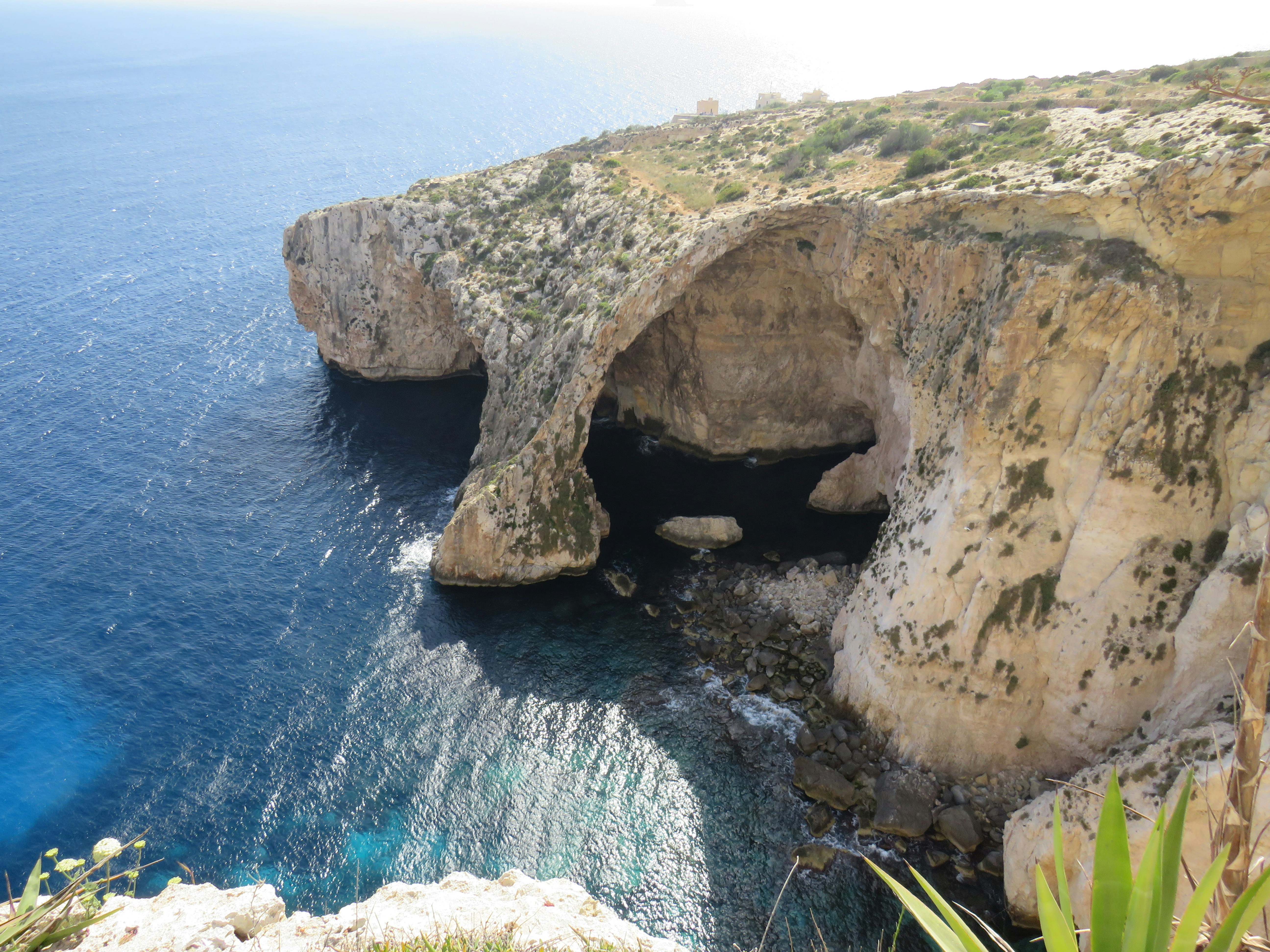 A rocky cliff overlooks a body of water photo – Free Malta Image on ...