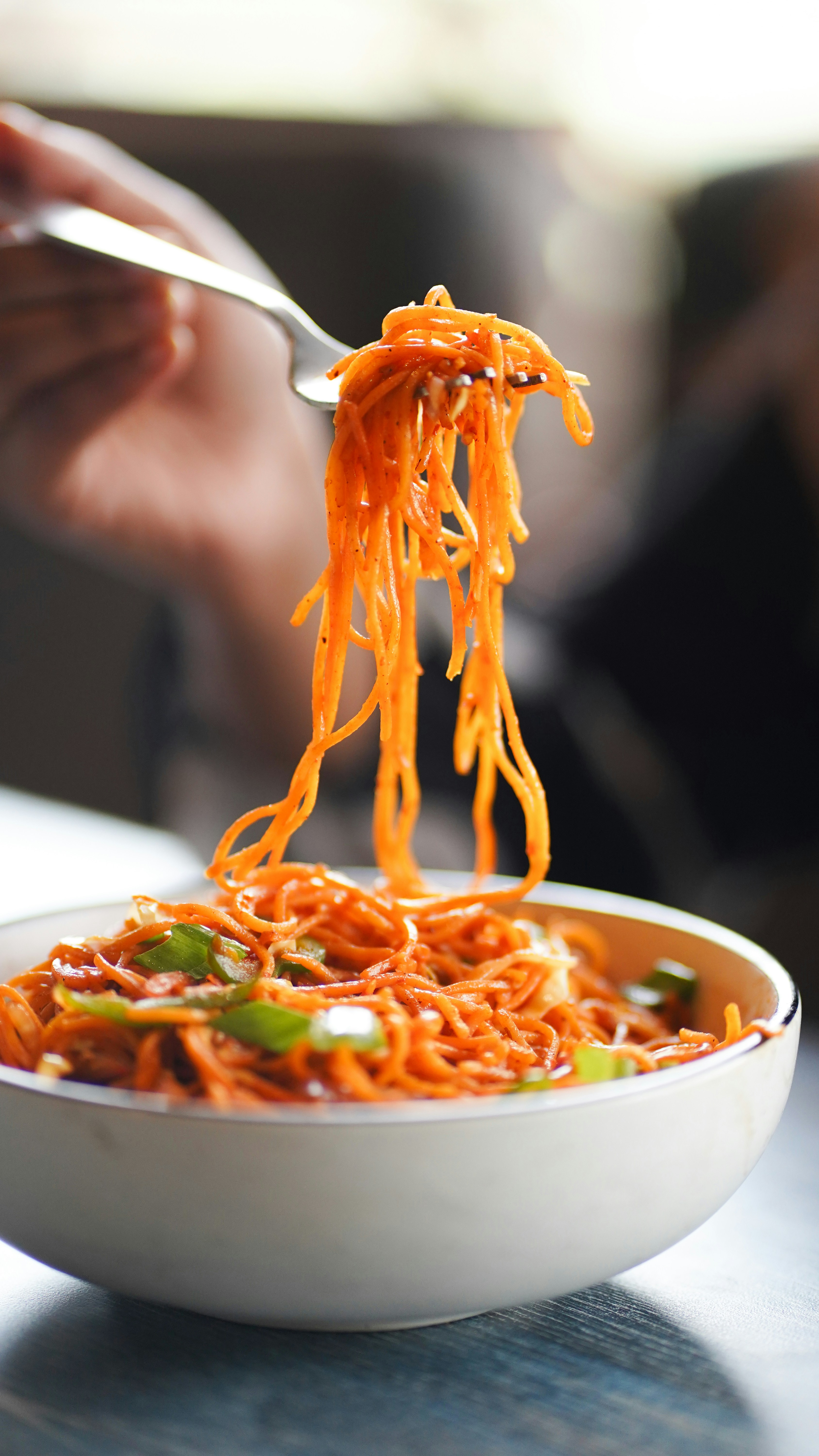 a person is eating a bowl of noodlesMustafa Fatemi