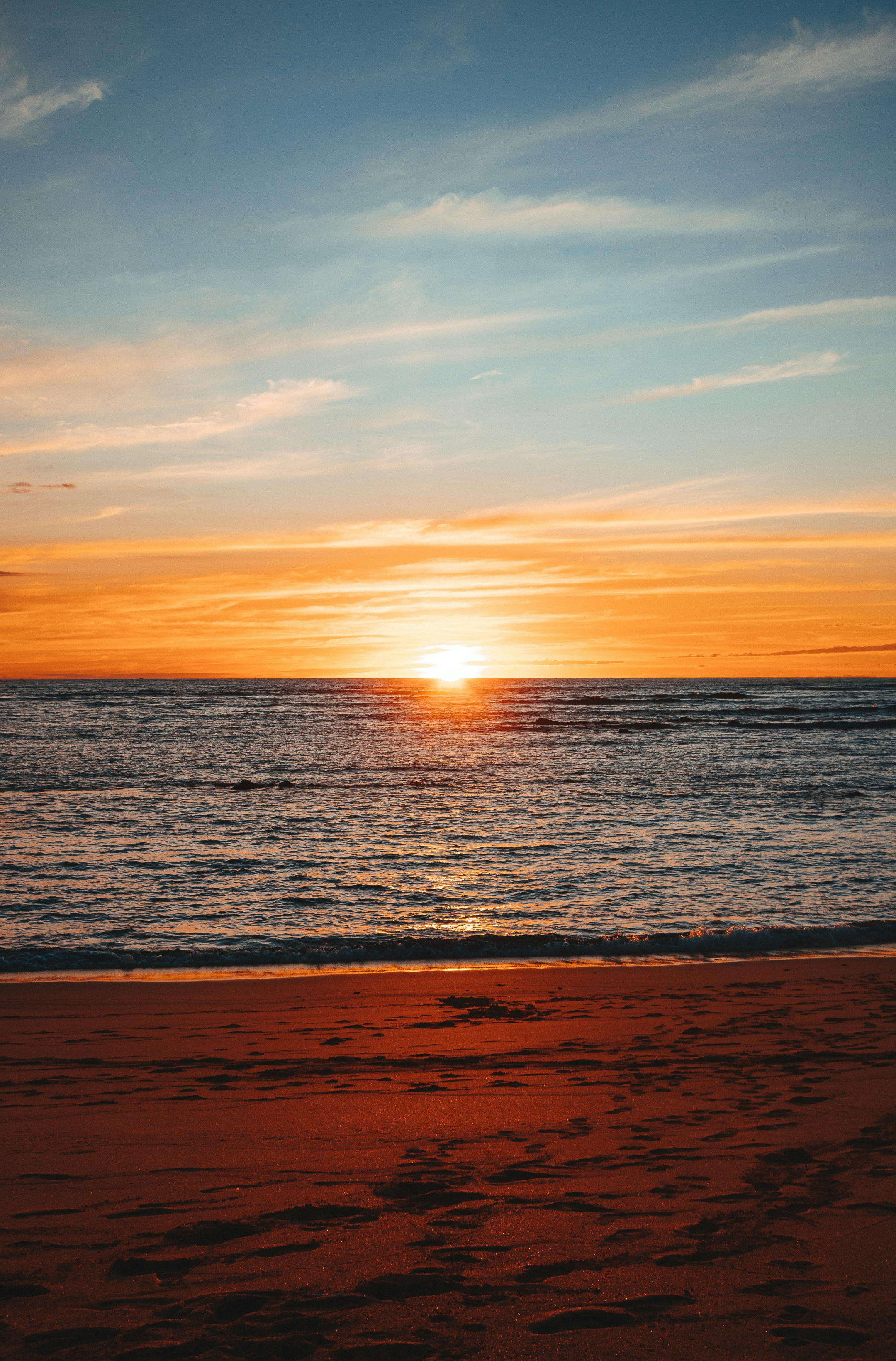 The sun is setting over the ocean on the beach photo – Free Beach Image on Unsplash