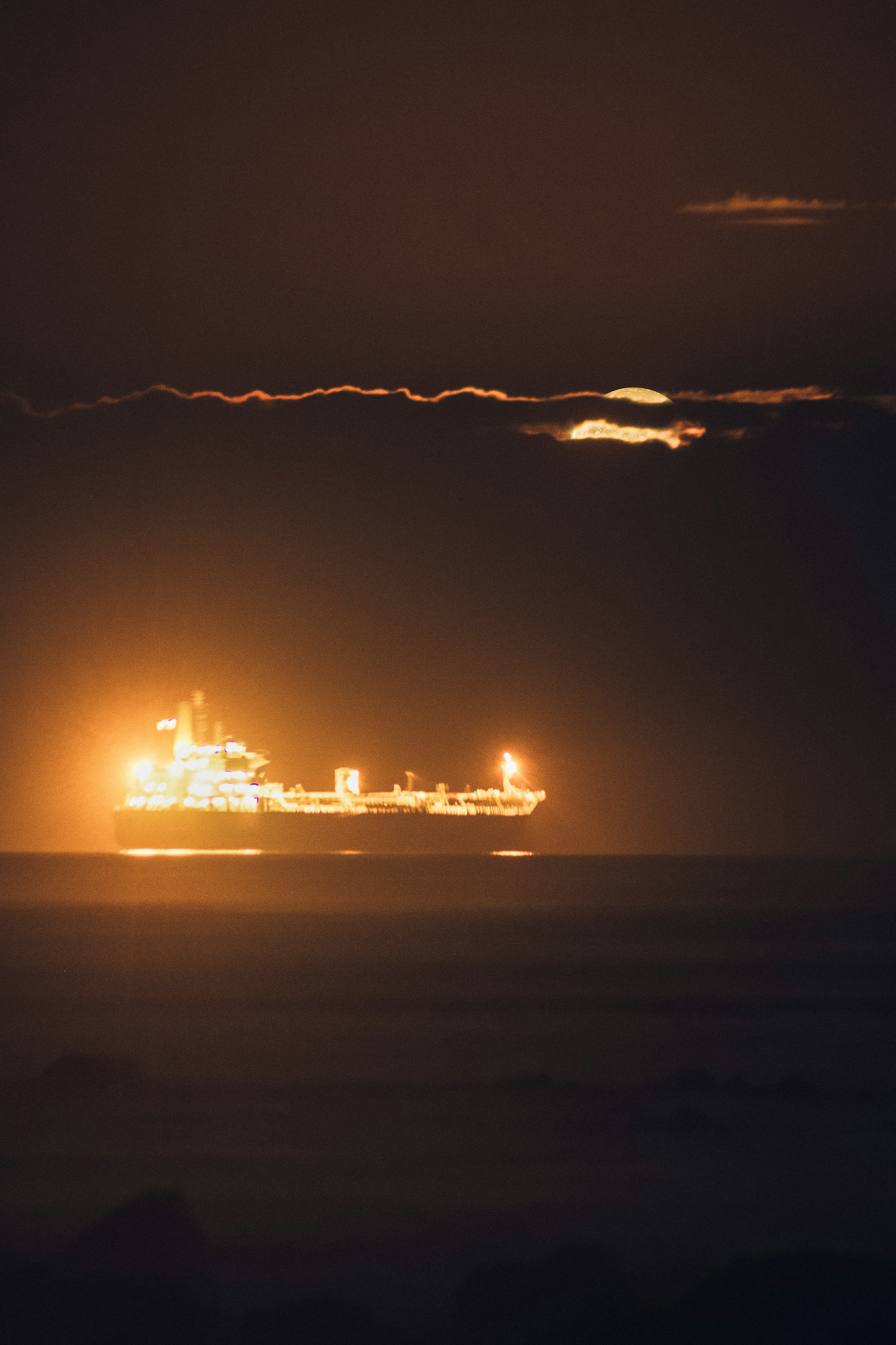 Ember-Lit Freighter Drifting Across a Quiet Night Ocean