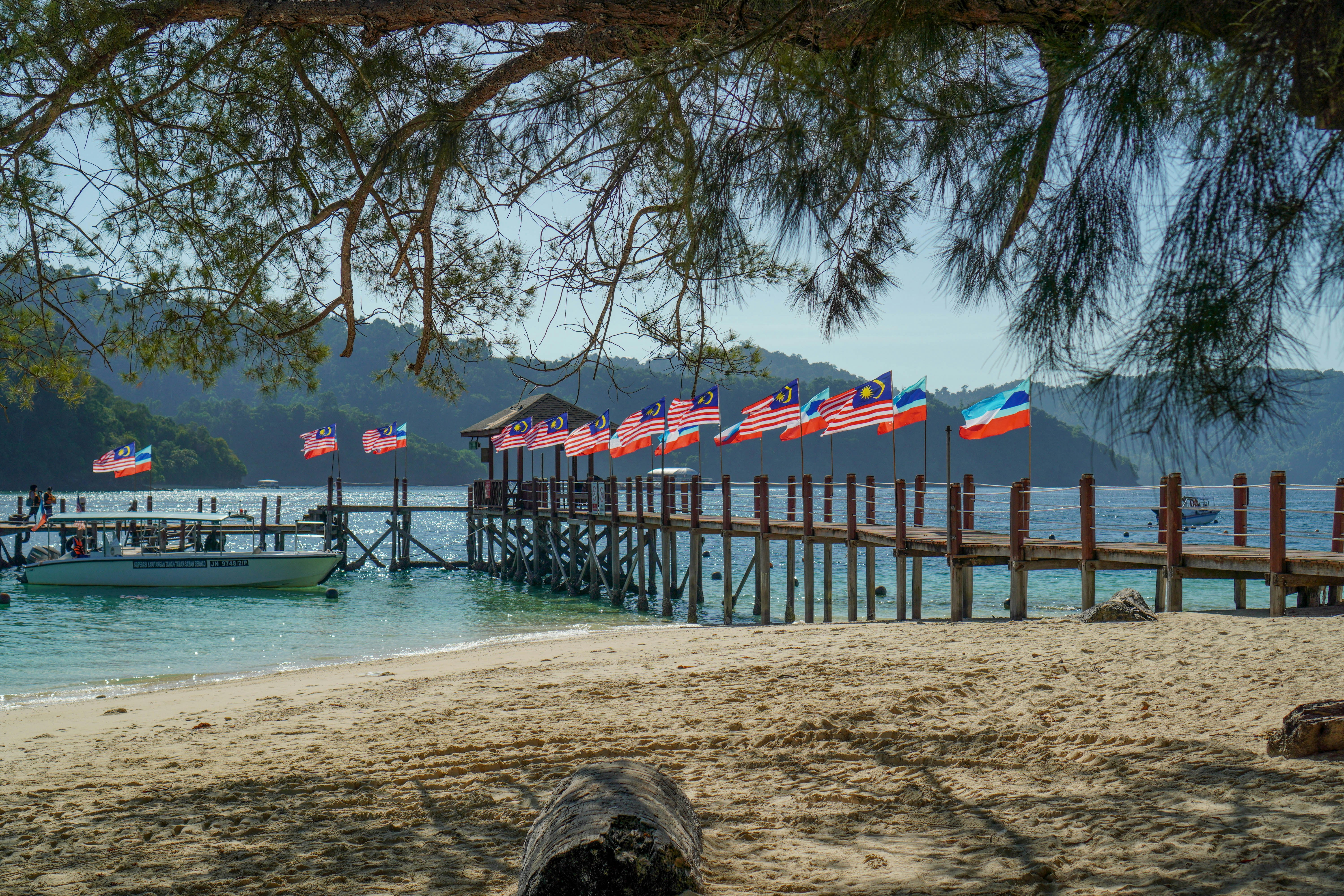Flags Along a Sunlit Pier Stretch Across Turquoise Bay