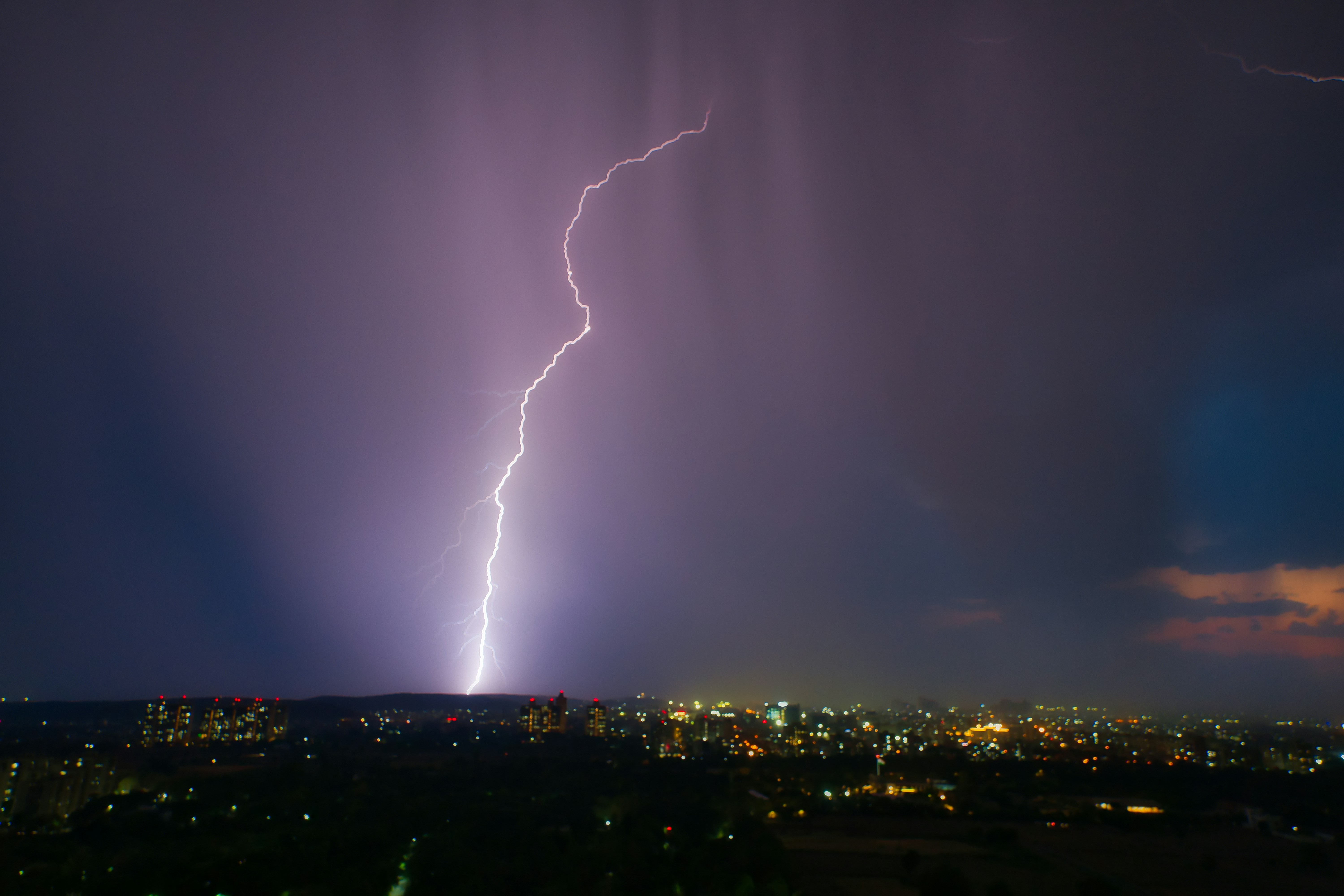 A lightning bolt hitting over a city at night photo – Free Manesar ...