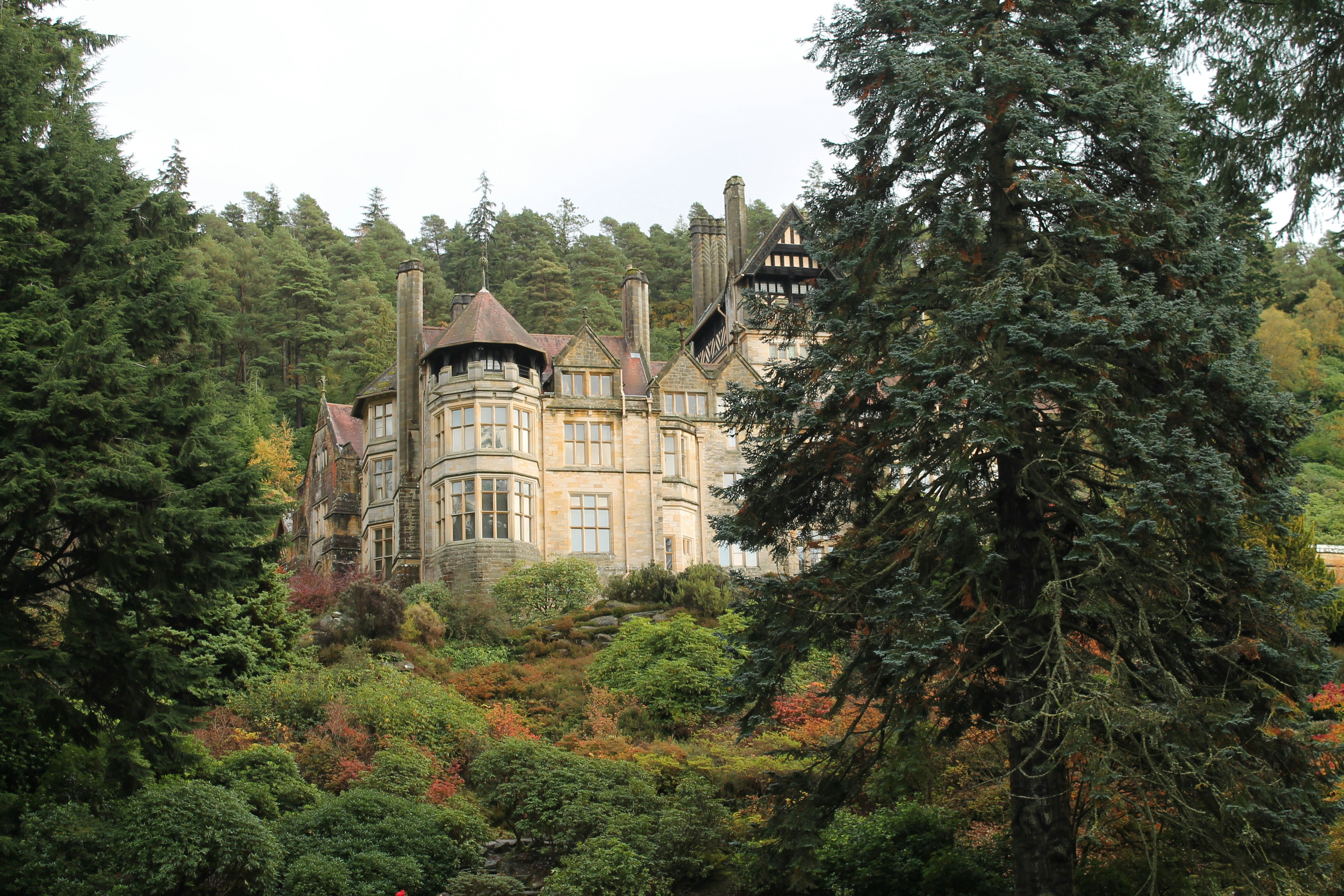 A large building sitting on top of a lush green hillside photo – Free ...