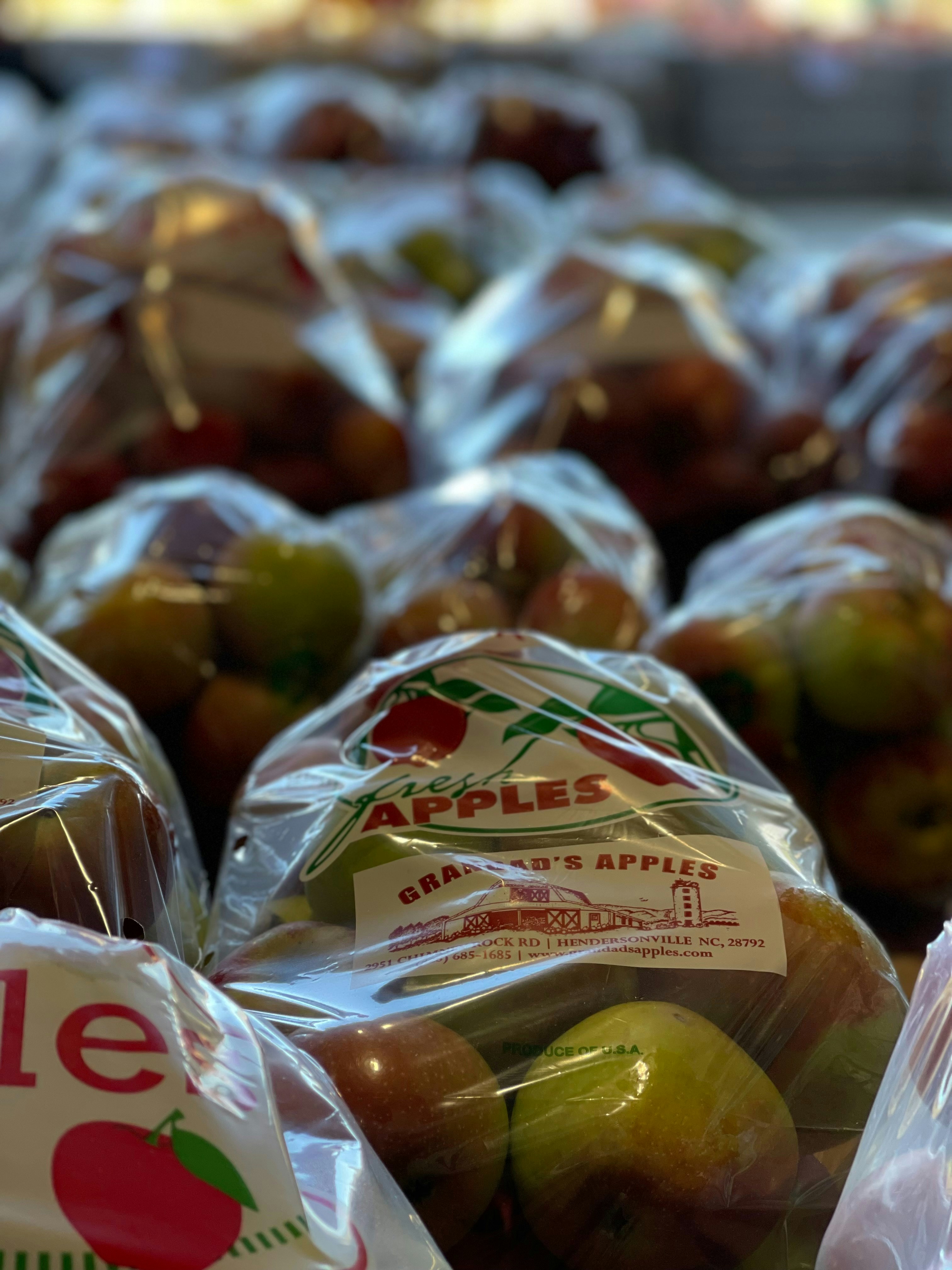 Apples wrapped in plastic are on display in a store photo – Free Food ...