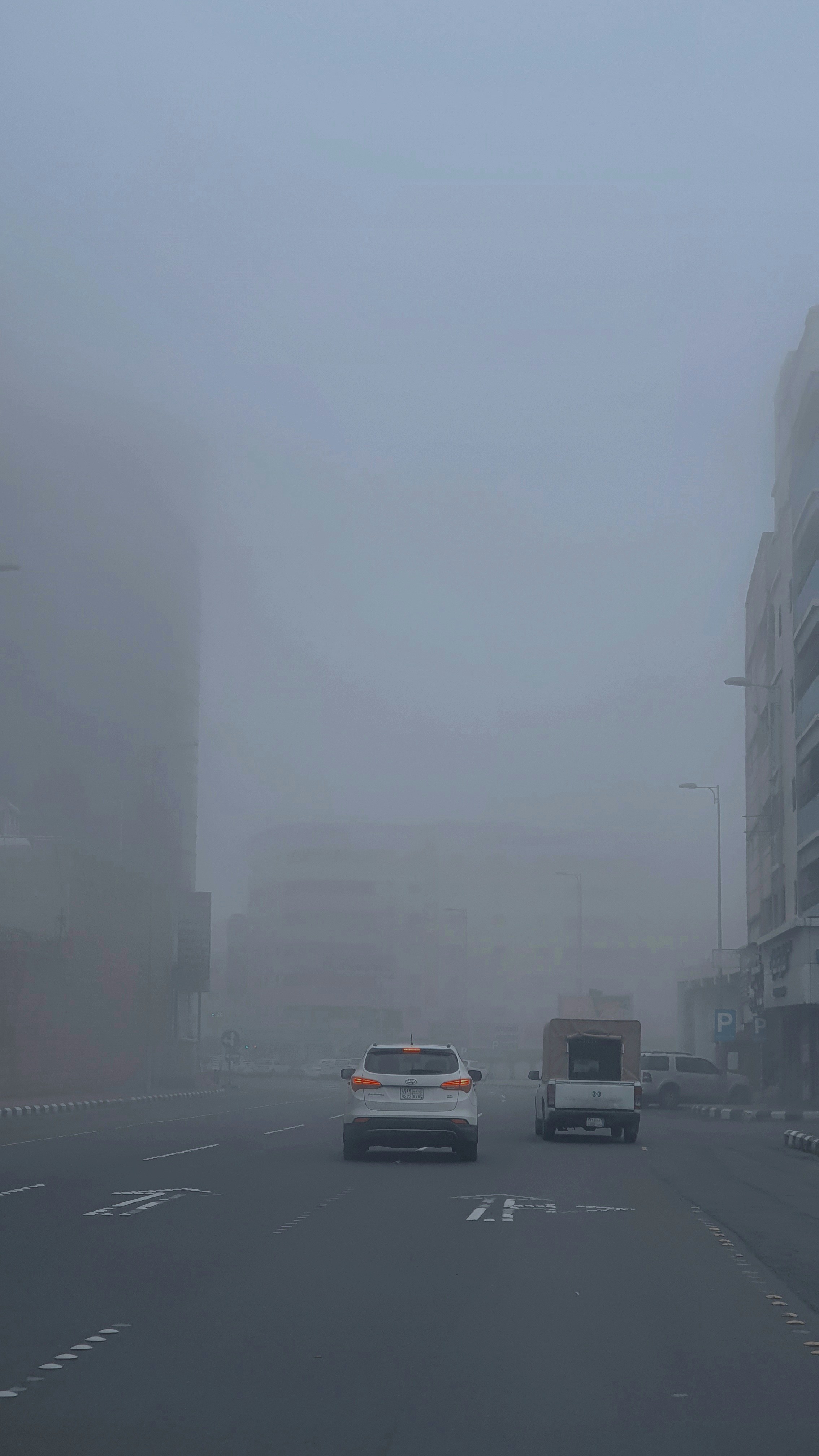 Two cars driving down a street in the fog photo – Free Abha saudi ...