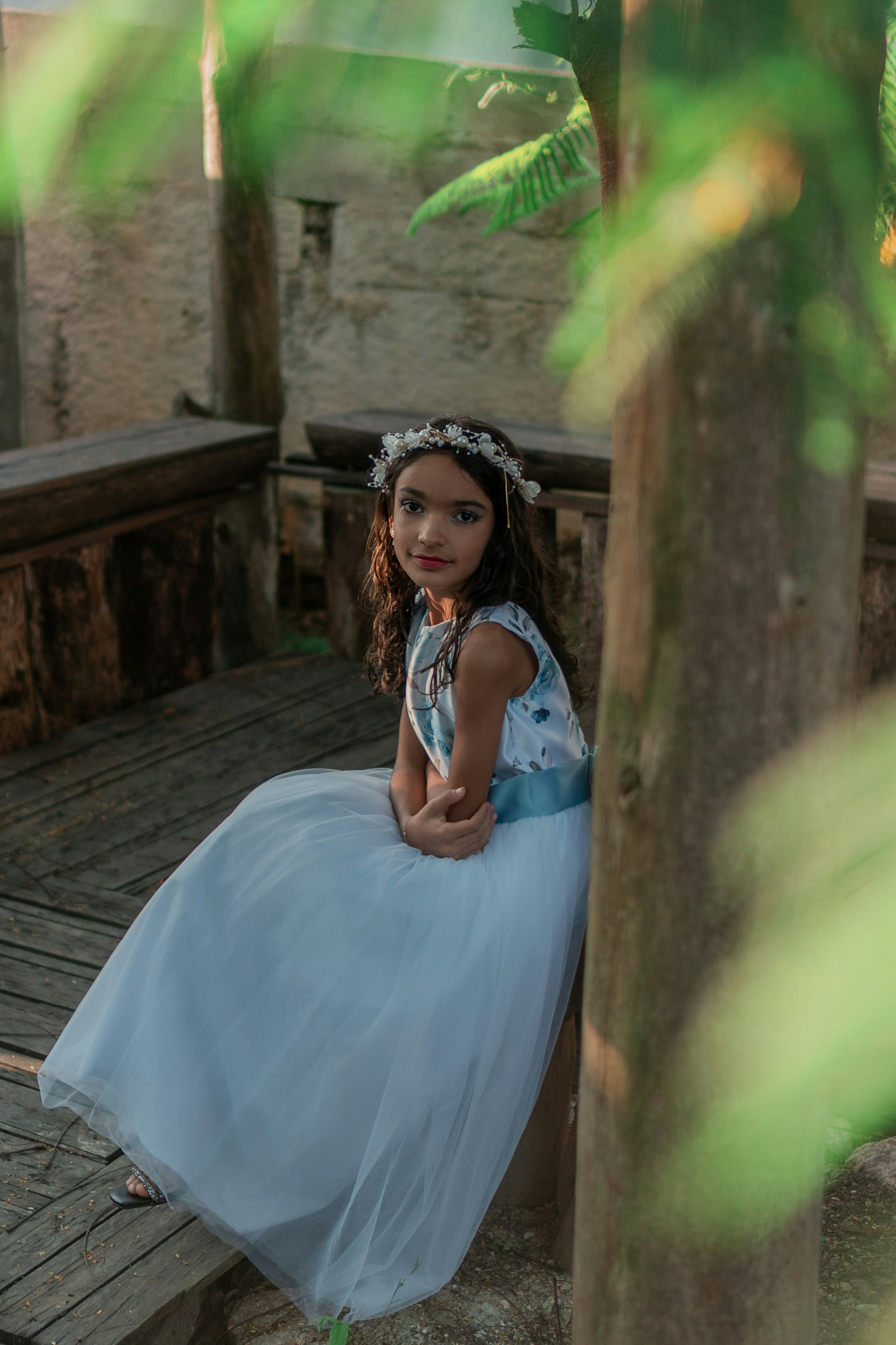 A little girl in a blue dress sitting on a wooden deck photo – Free ...