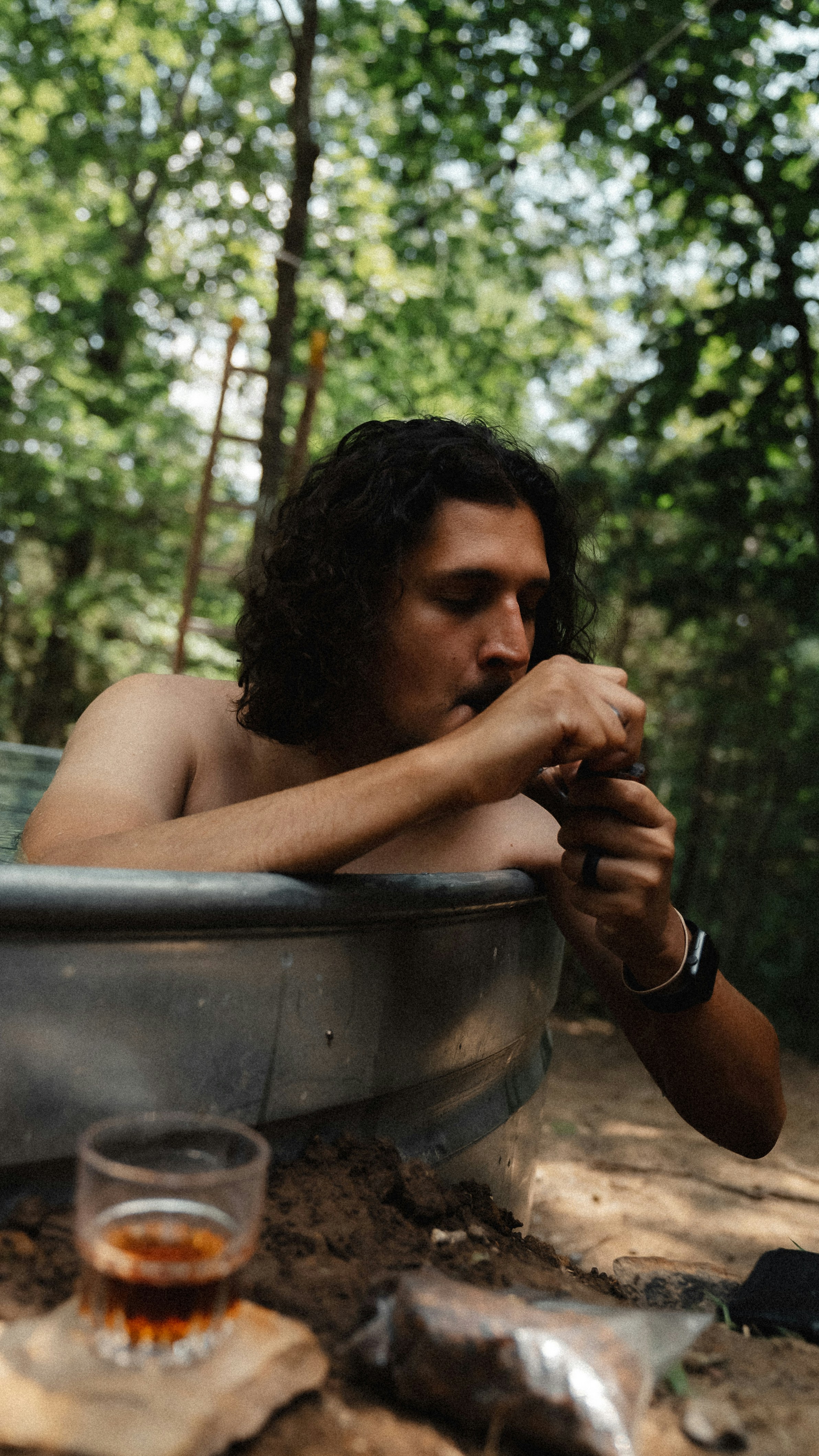 a man sitting in a tub in the woods