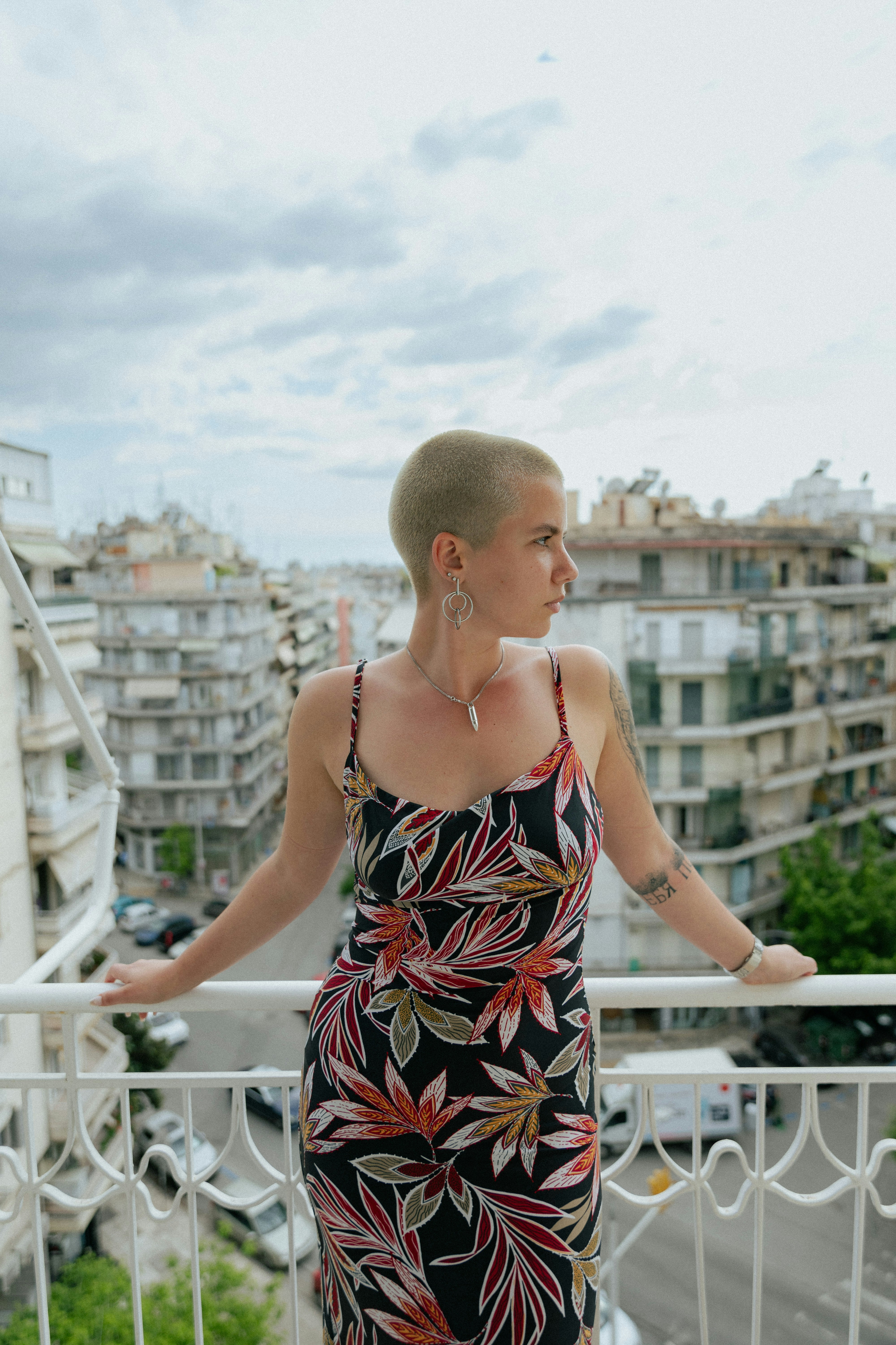 Balcony Portrait in a Bold Floral Dress Against a City Mosaic
