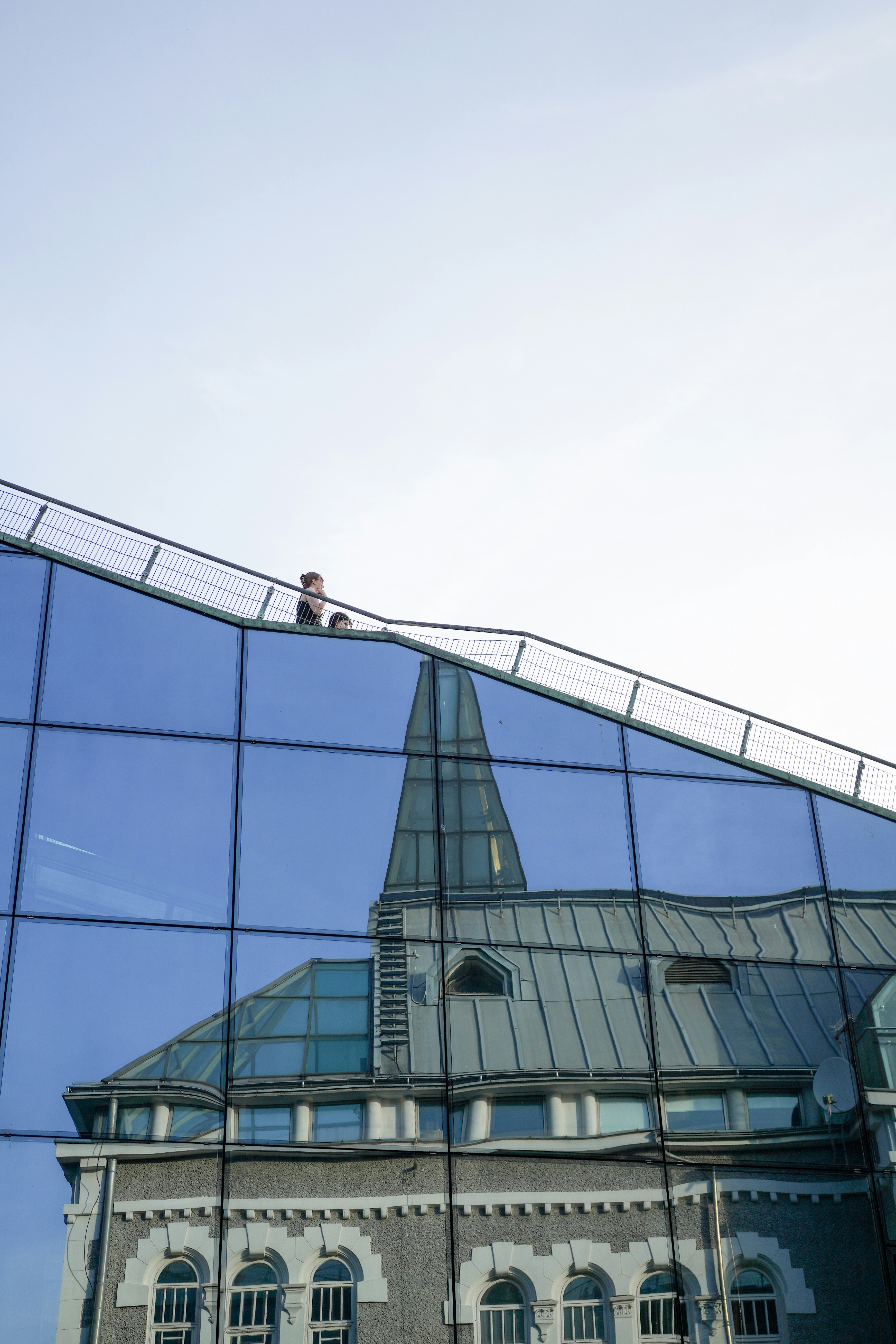 Rooftop Edge: A Figure Framed by Glass Reflections