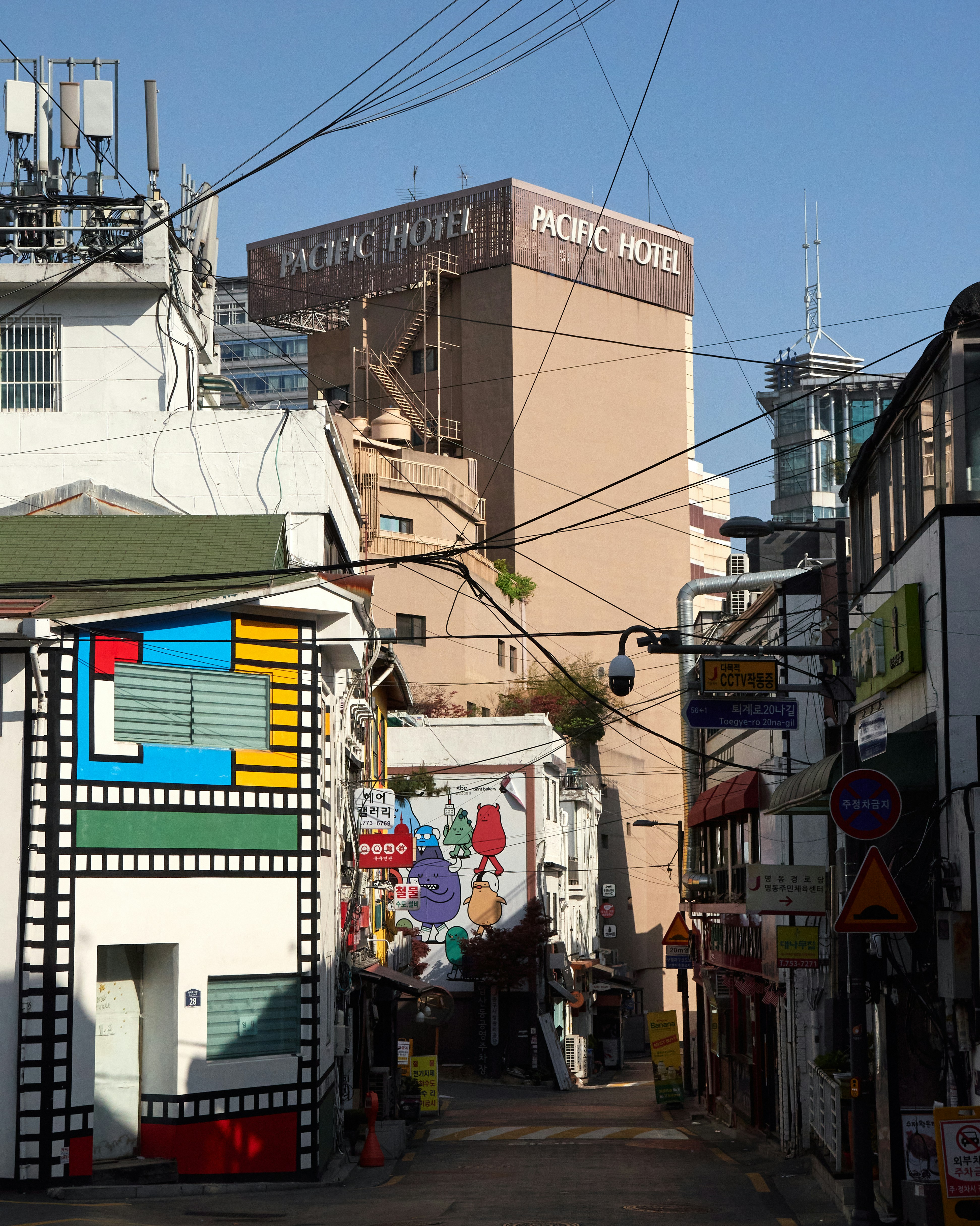 Pacific Hotel Overlook: A Narrow Street Framed by Murals and Signage